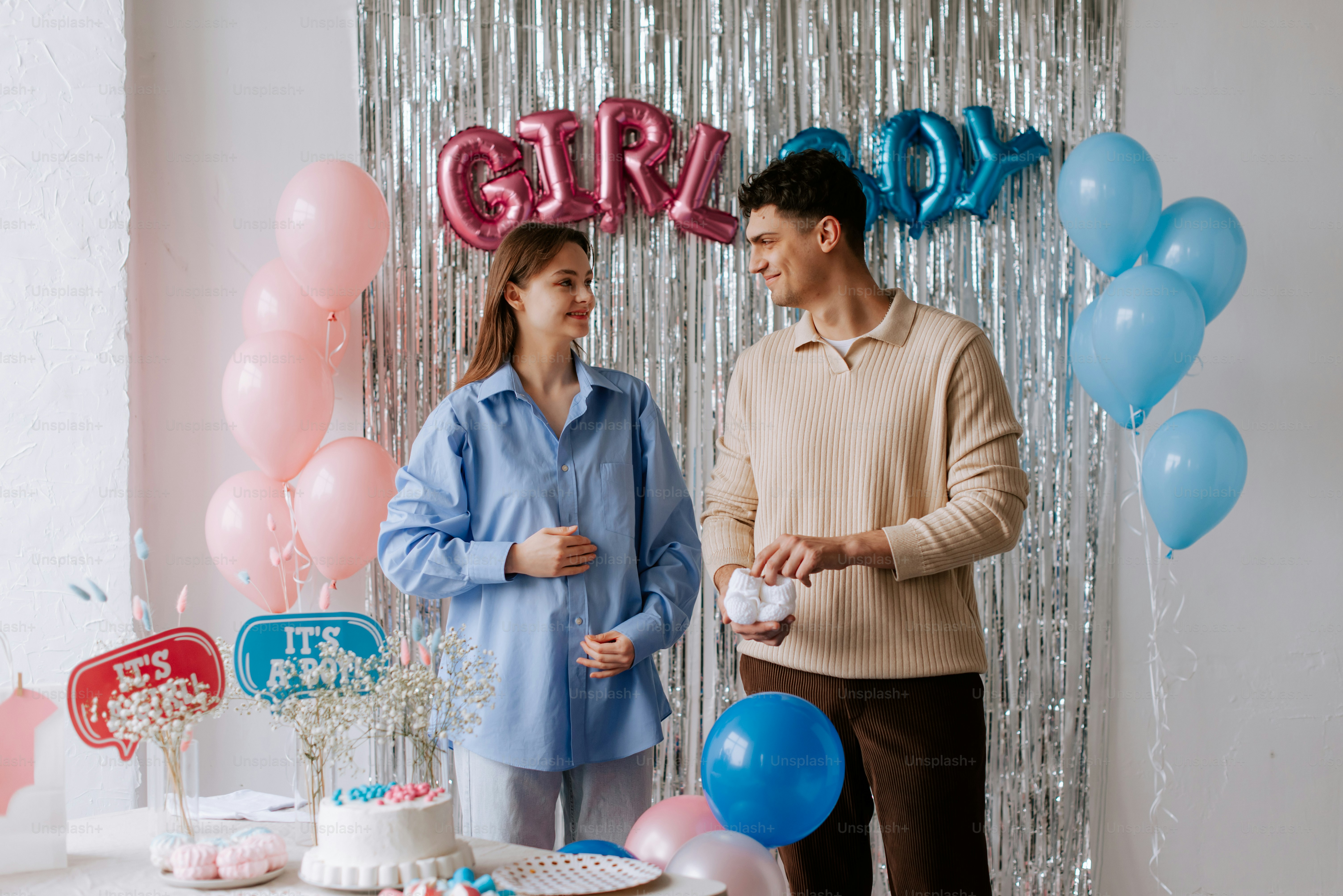 A man and a woman standing in front of a wall with balloons photo ...