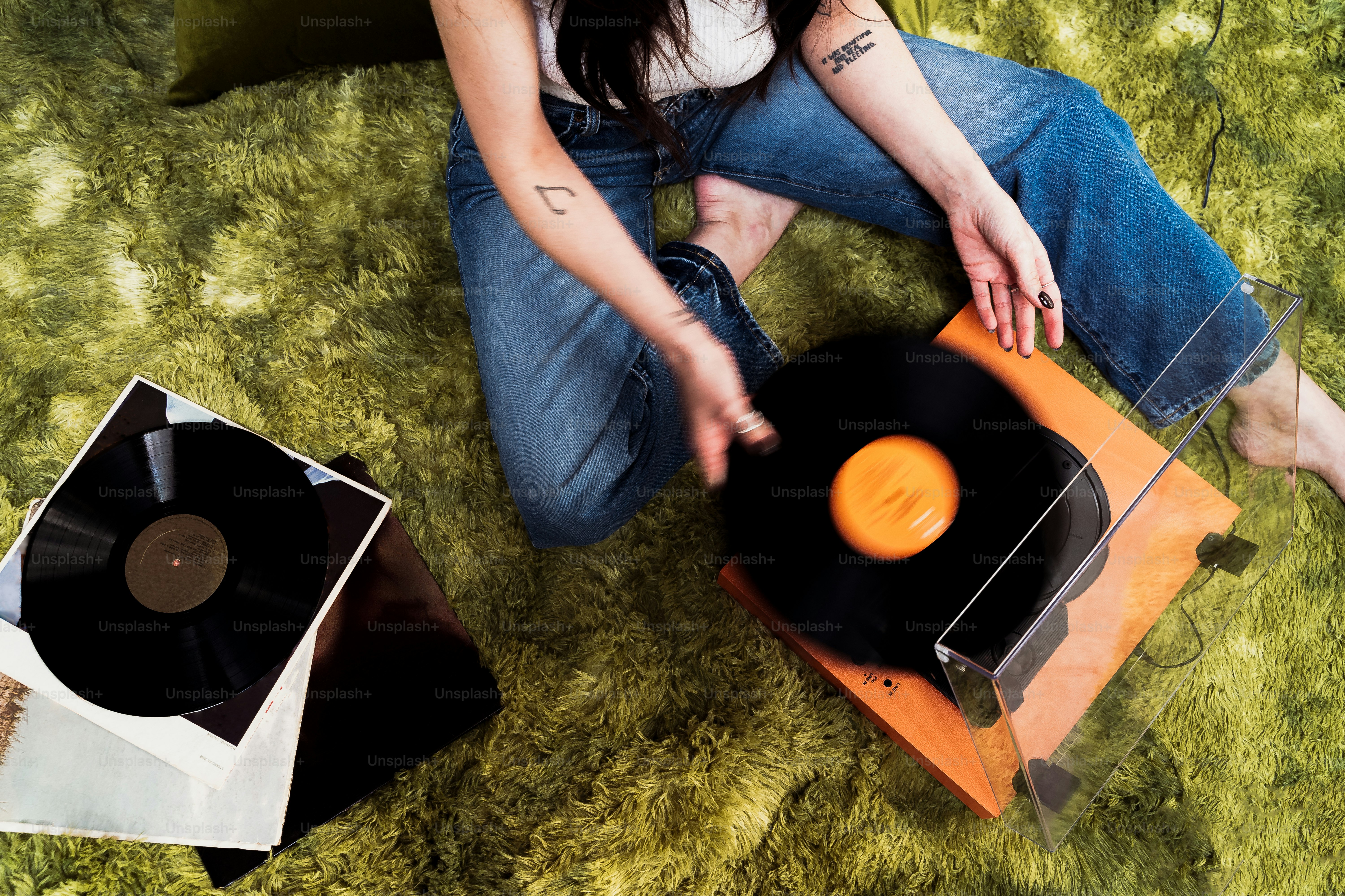 A woman sitting on a bed with a record player photo – Playing records ...