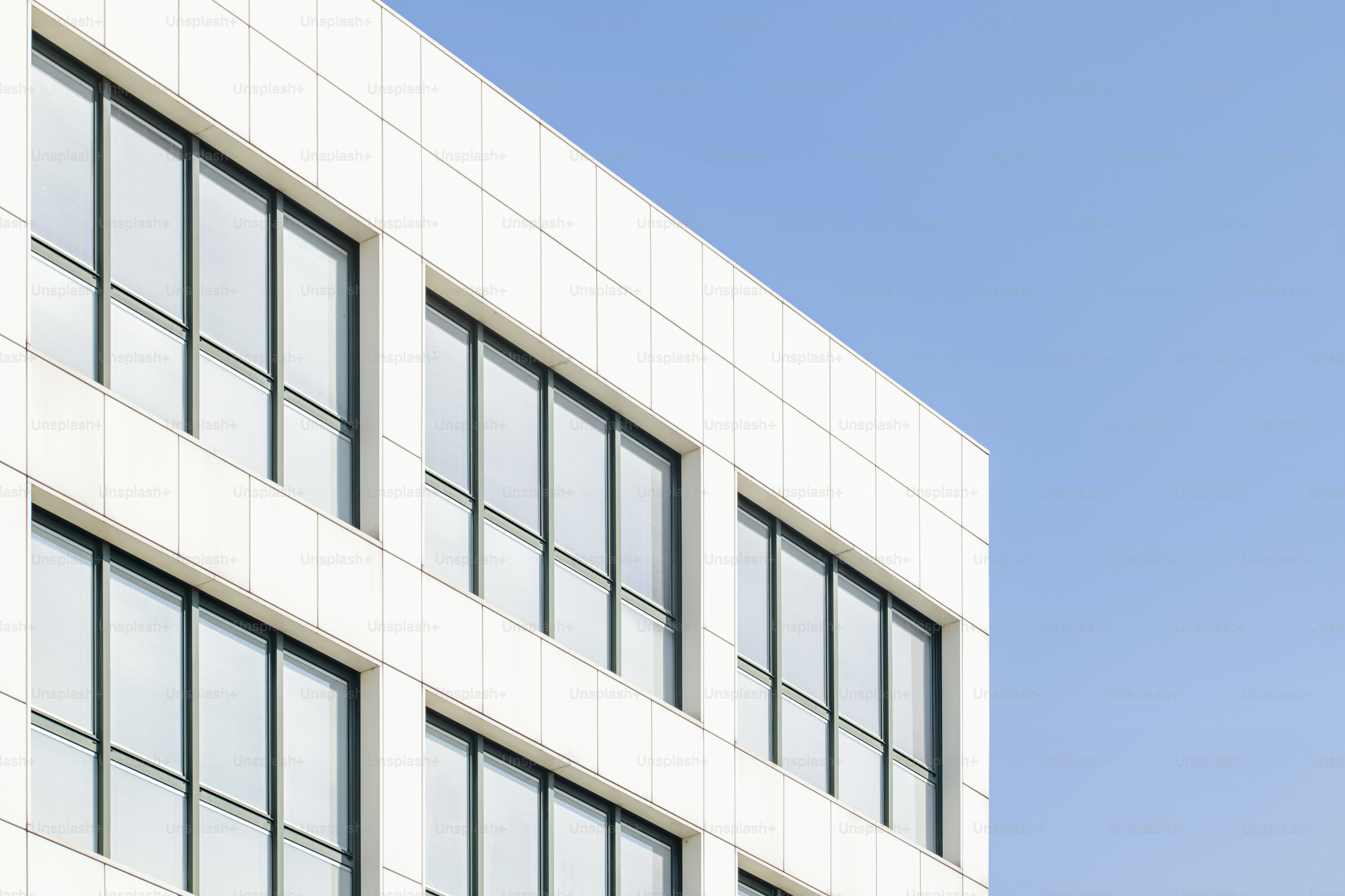 A large white building with many windows on it photo – White Image on ...