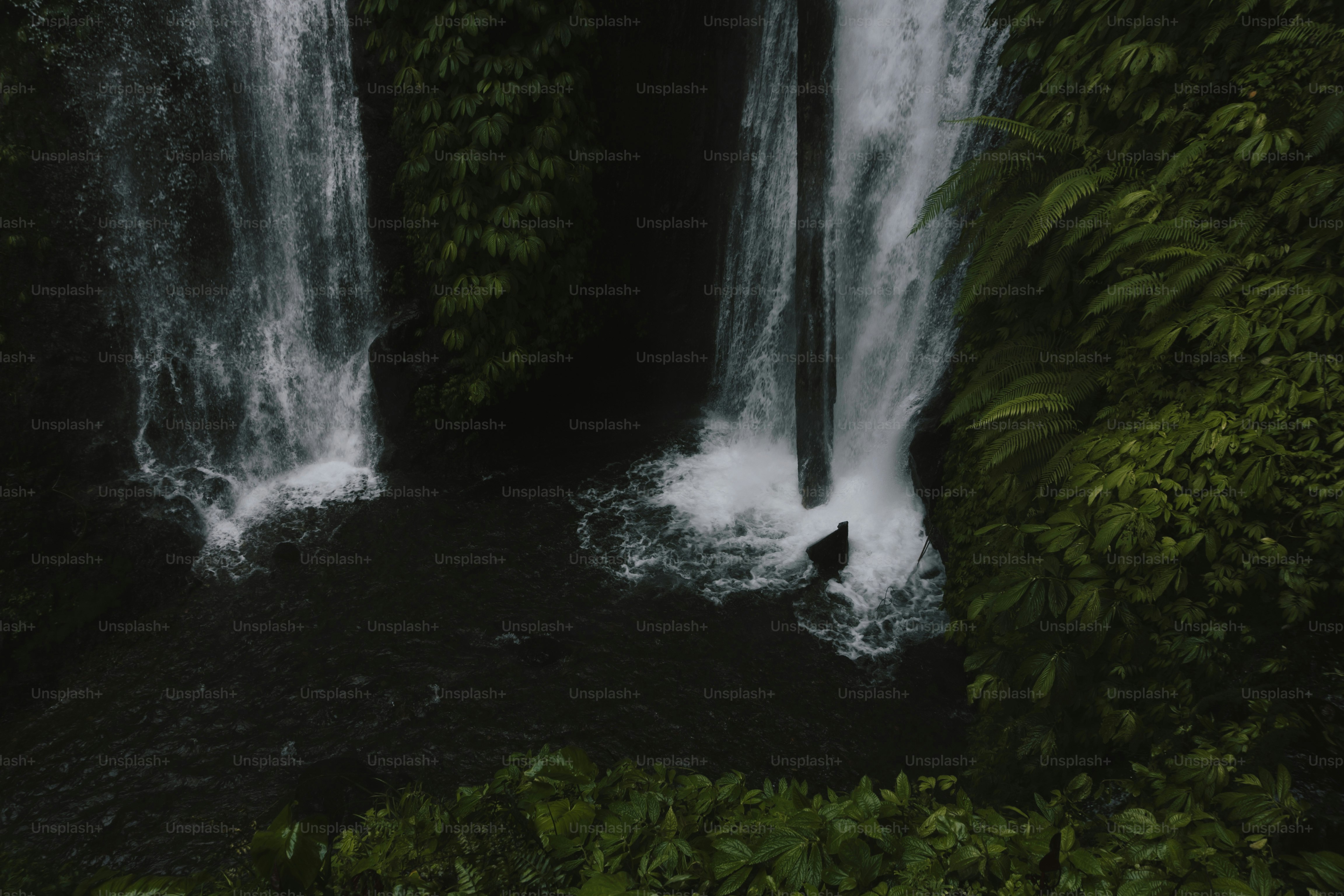 A man standing in the middle of a waterfall photo – Moody nature Image ...