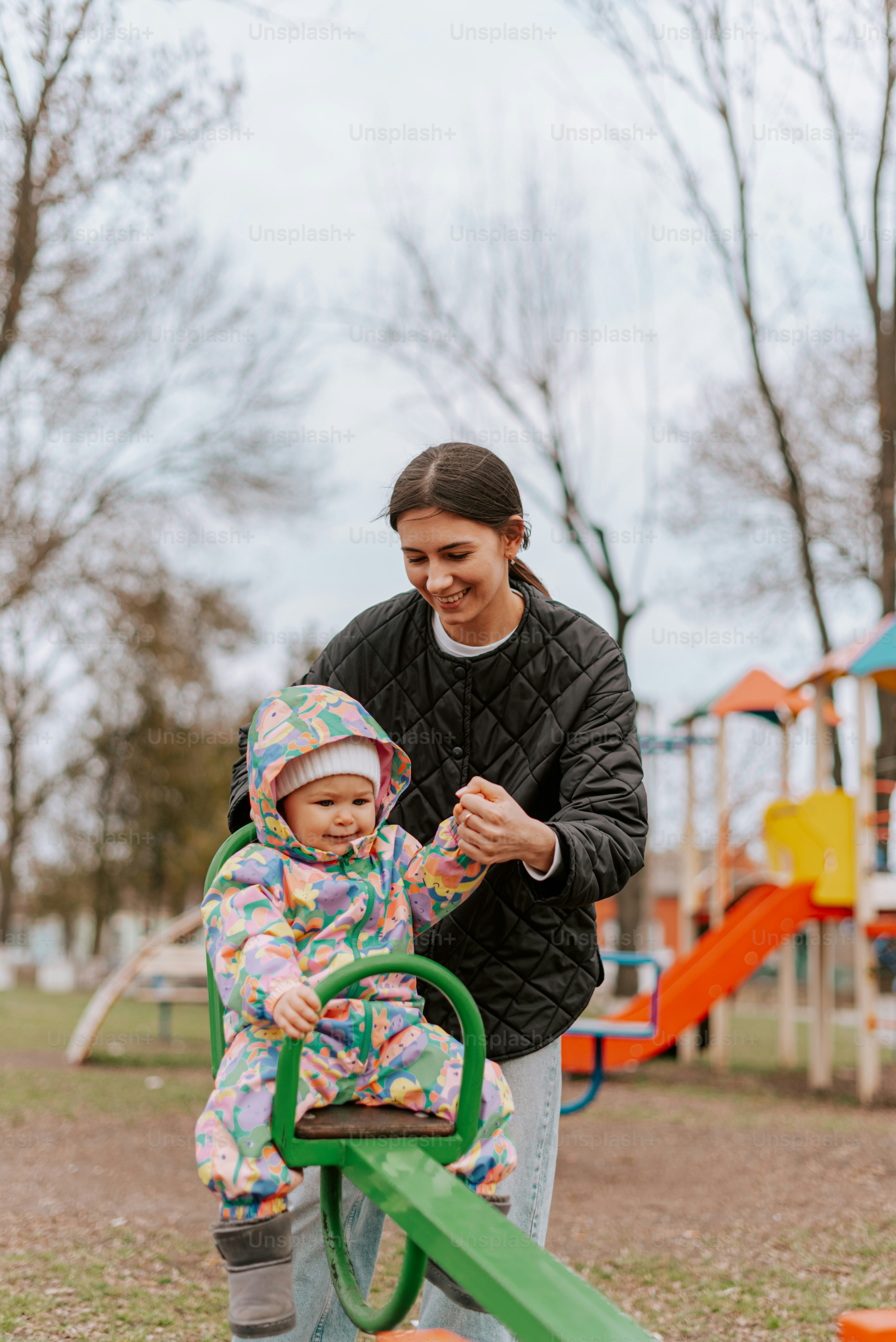 A woman playing with a toddler on a playground photo – Playground Image ...