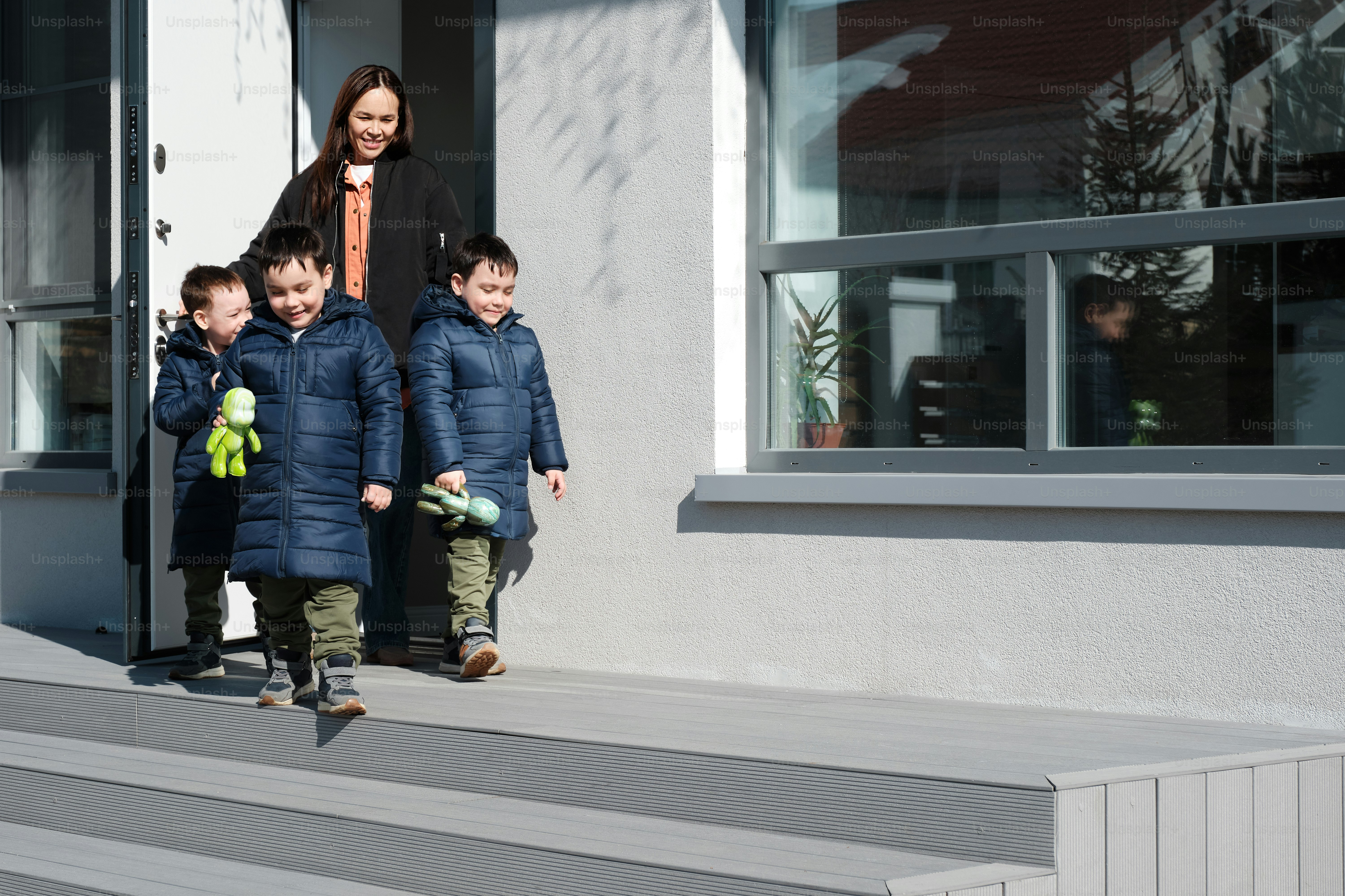 A woman and two children walking up a set of steps photo – Babysitter ...