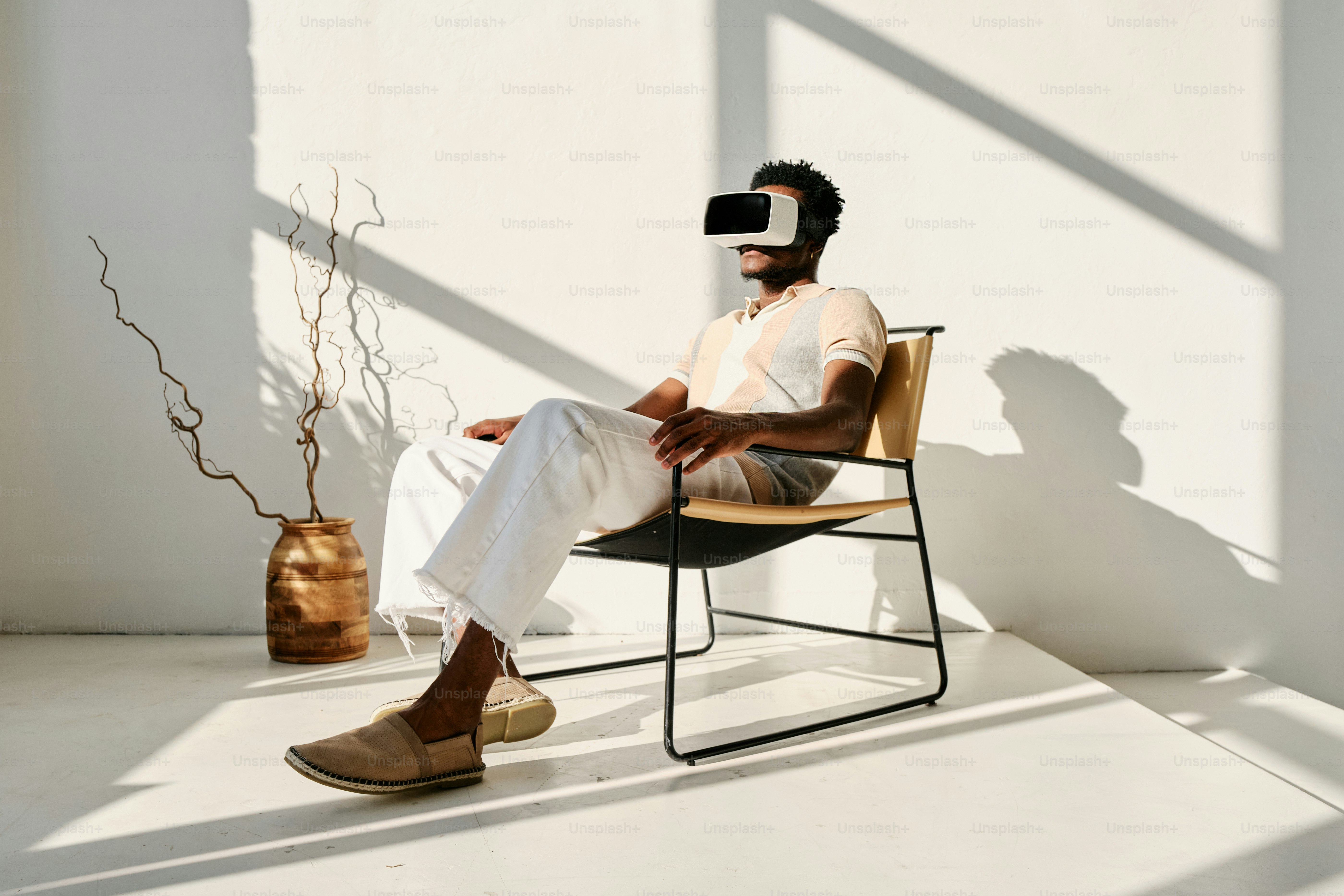 A man sitting in a chair wearing a virtual reality headset photo ...