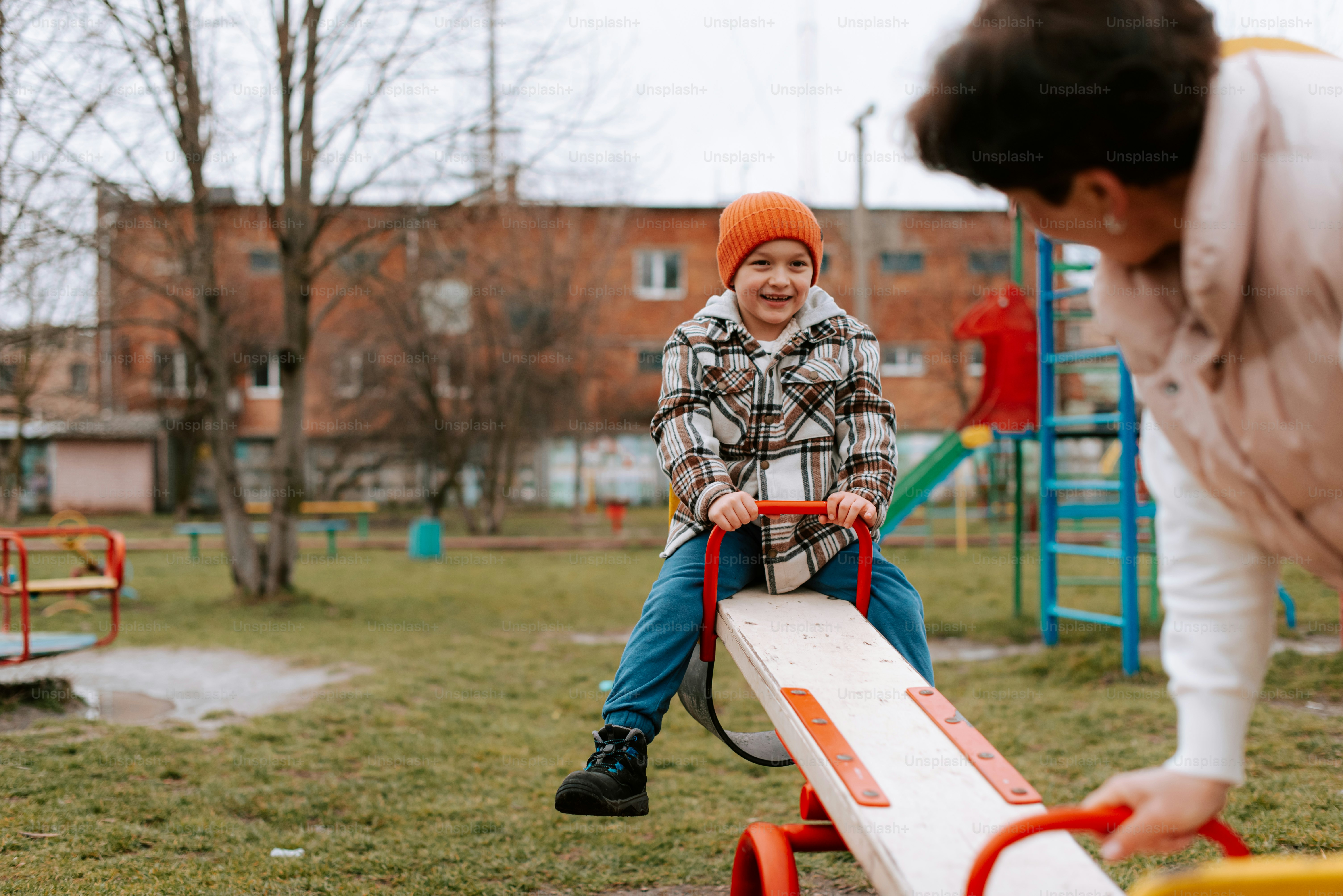 A young boy sitting on top of a wooden bench photo – Babysitting Image ...