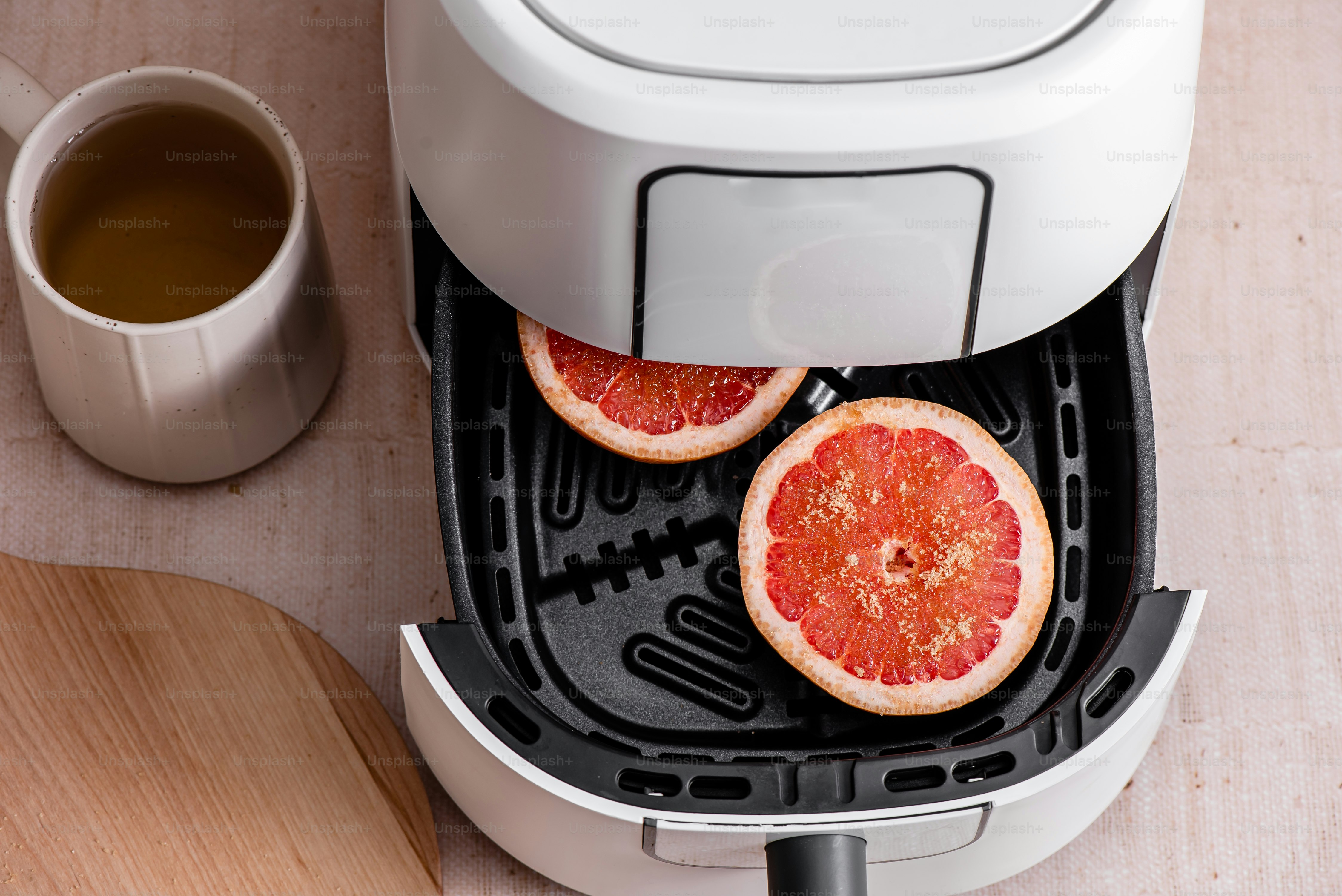 A couple of grapefruits sitting inside of a juicer photo – Pink ...