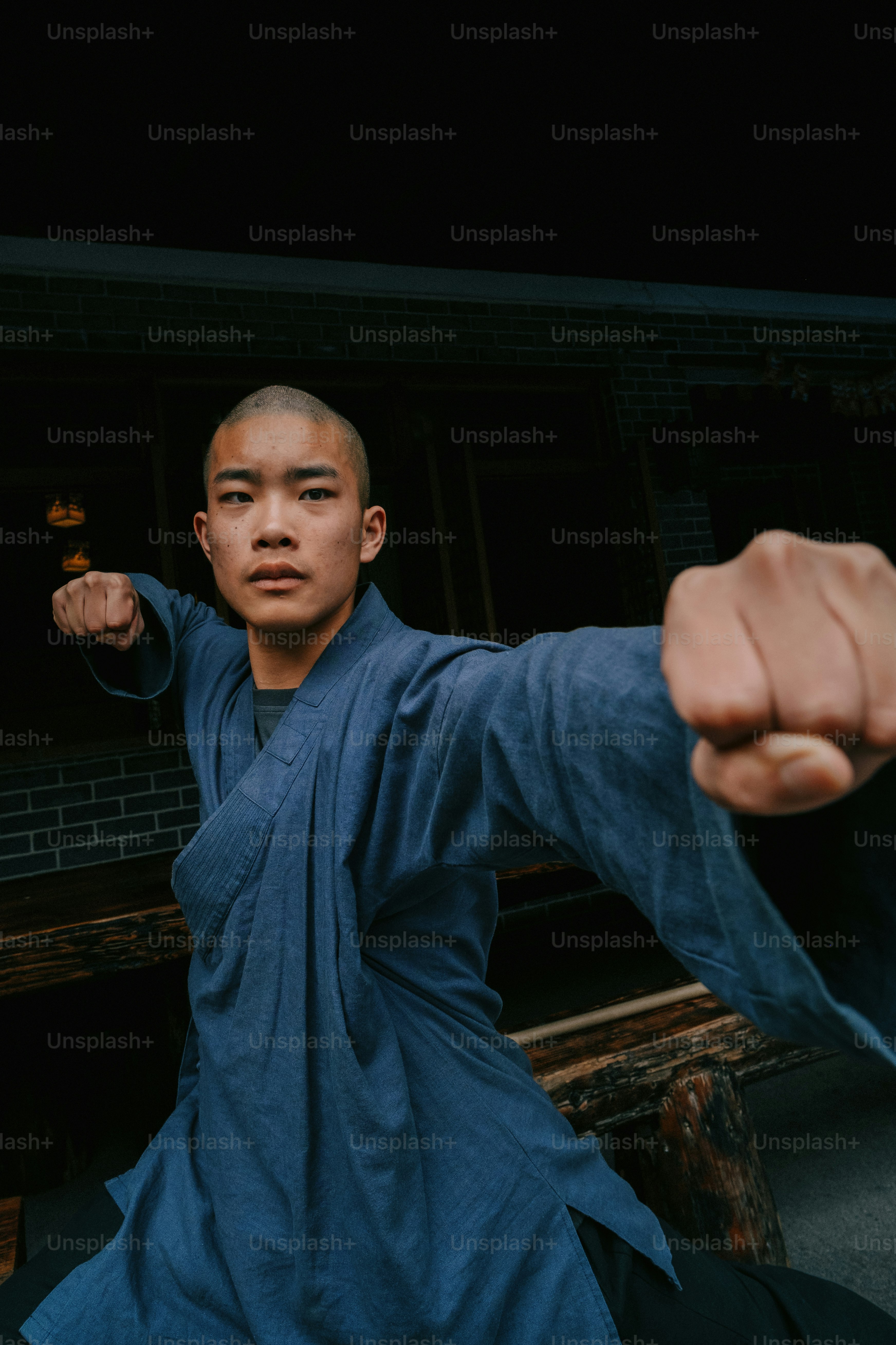 A man in a blue robe pointing a gun at the camera photo – Martial arts ...