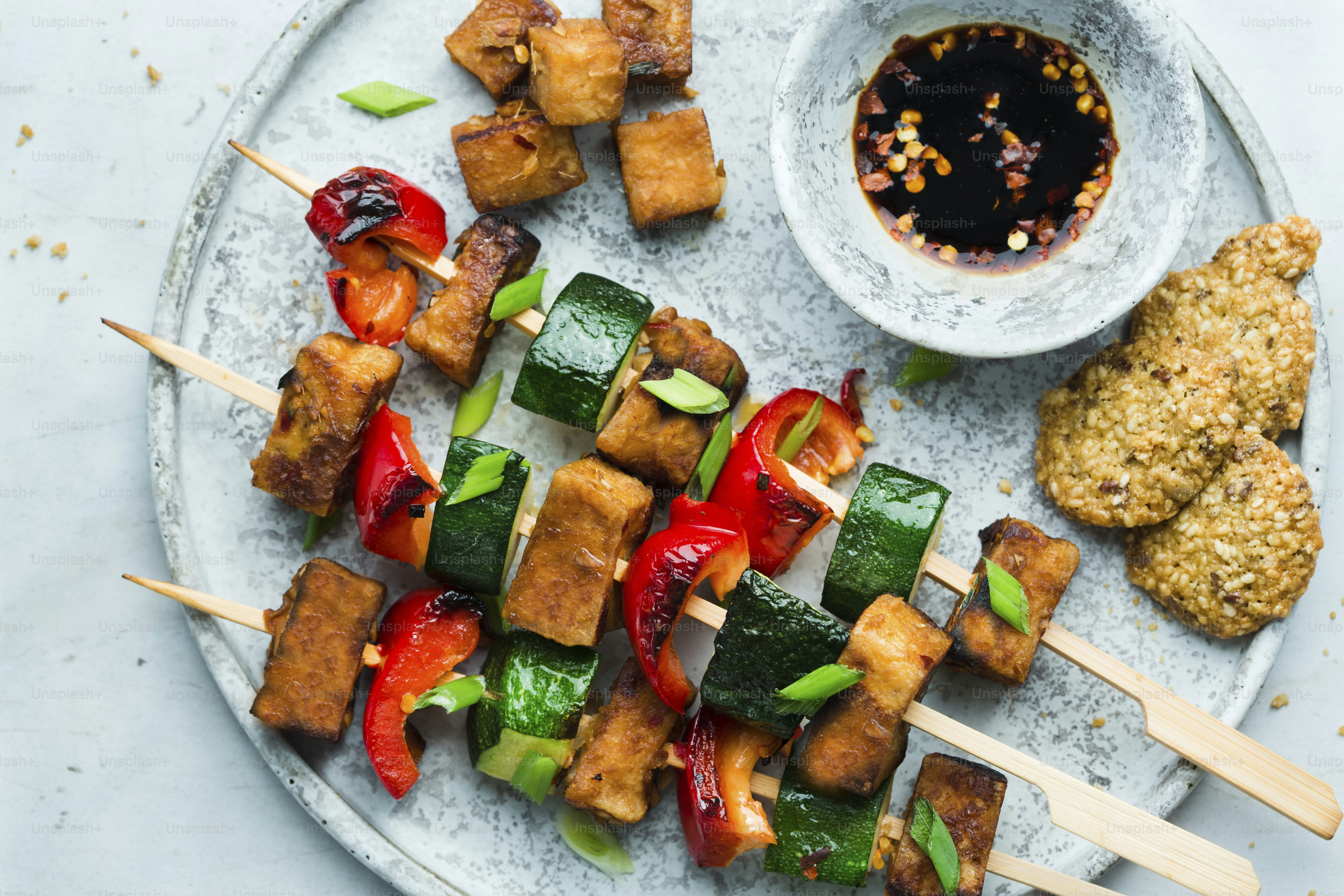 A plate of food with skewered vegetables and meat photo – Vegan protein ...