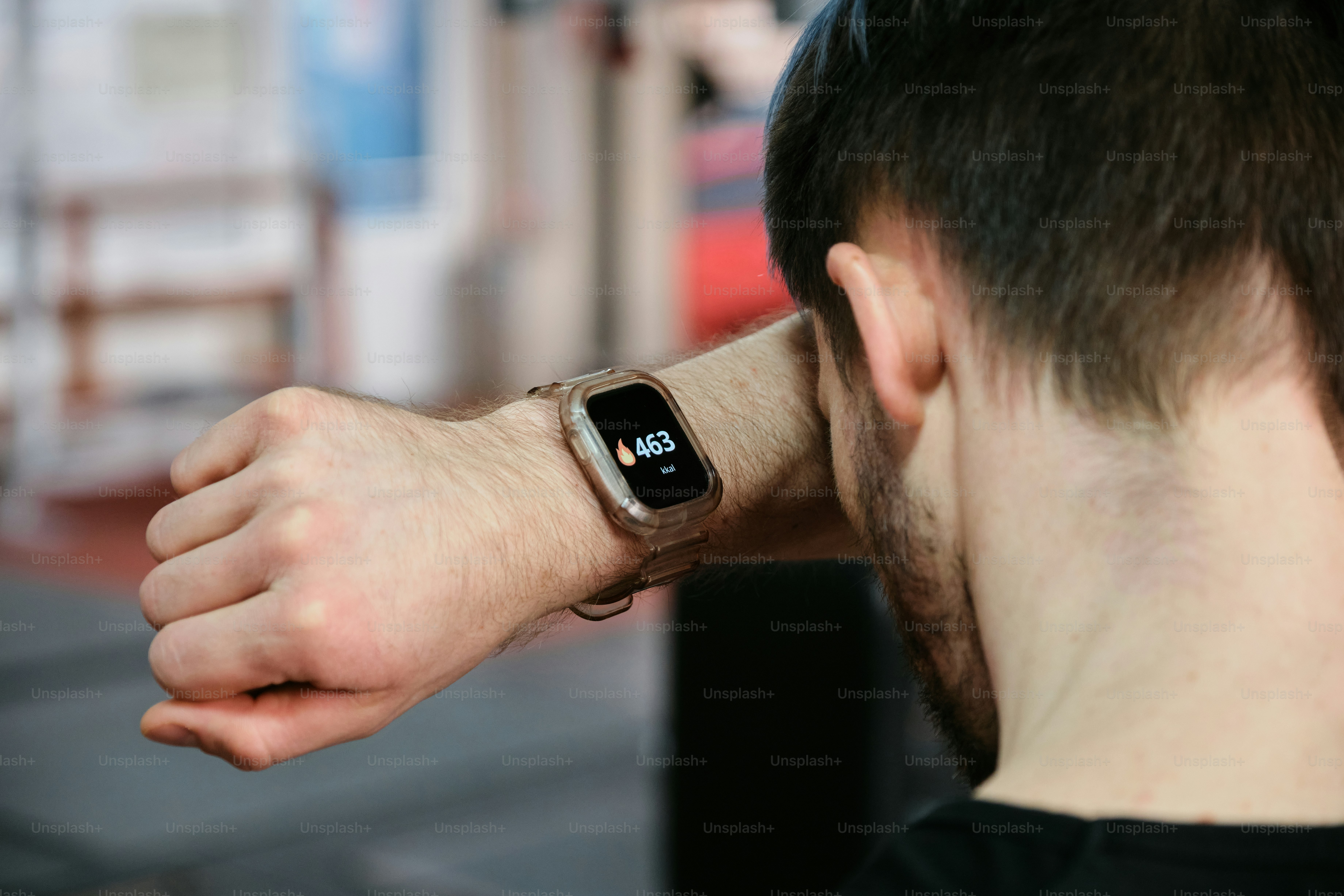 A man holding onto a smart watch on his arm photo – Health tech Image ...