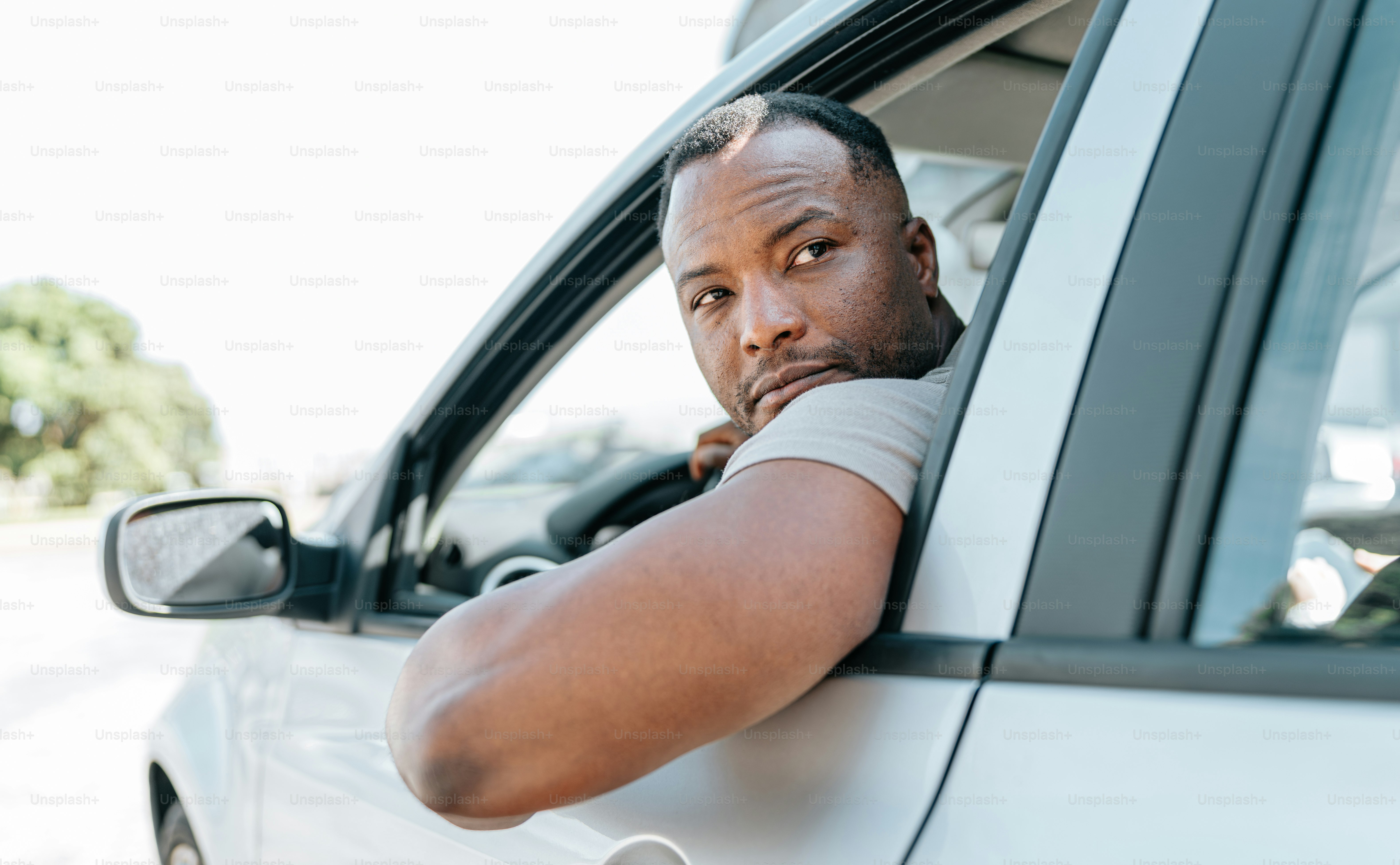 A man leaning his head out of a car window photo – Car Image on Unsplash