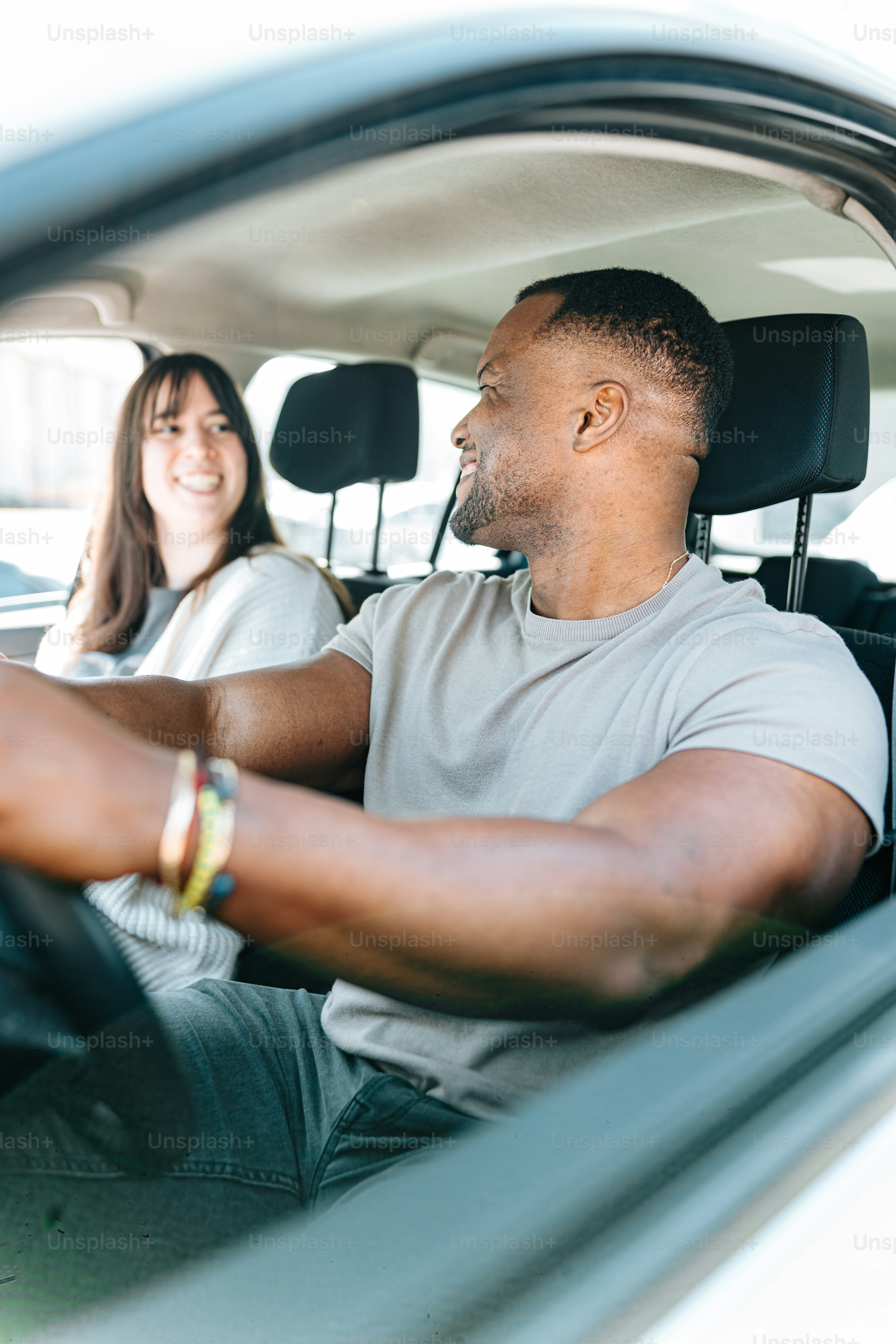 A man driving a car with a woman behind him photo – Learning Image on ...