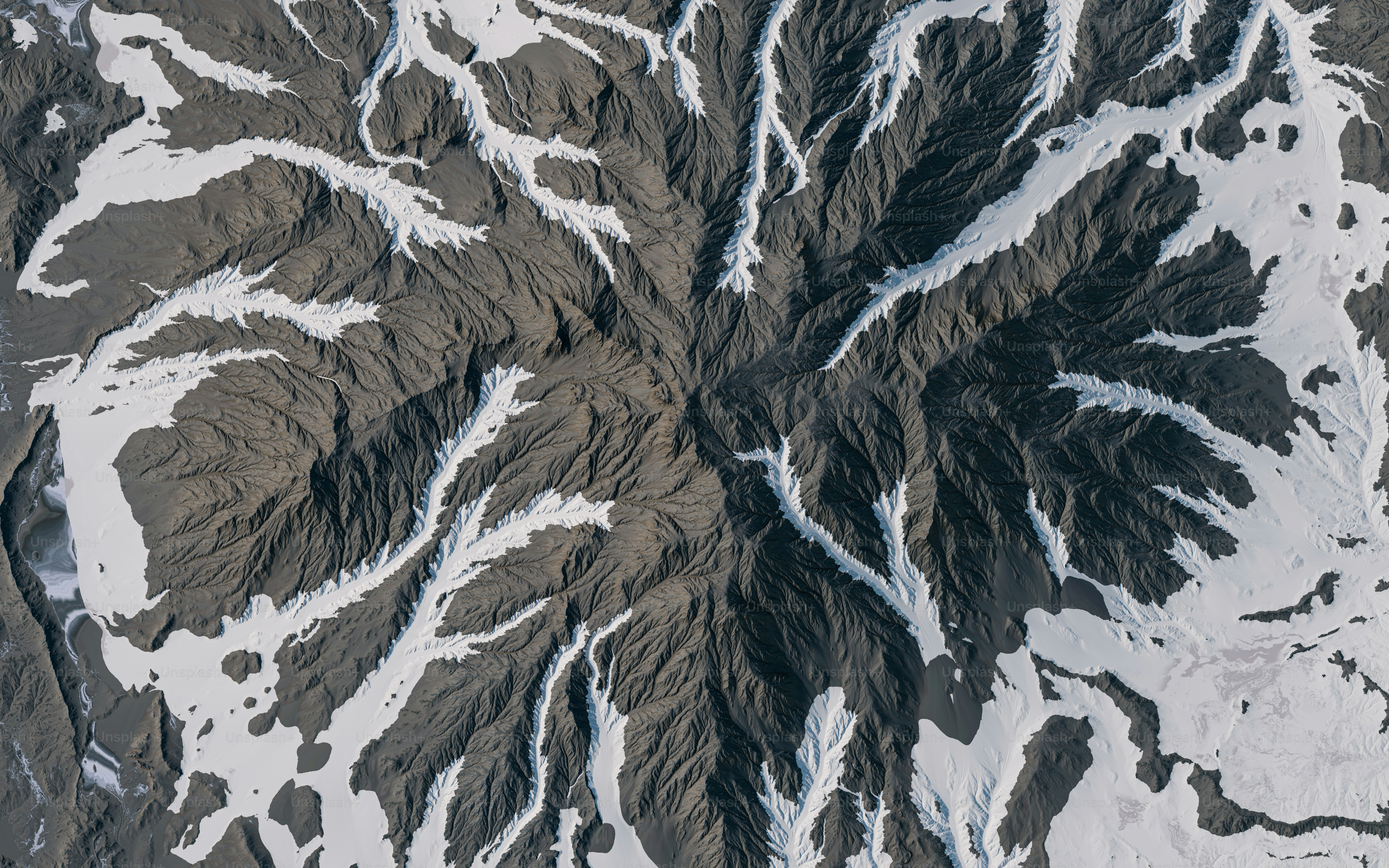 An aerial view of a snow covered mountain photo – Mountain range Image ...