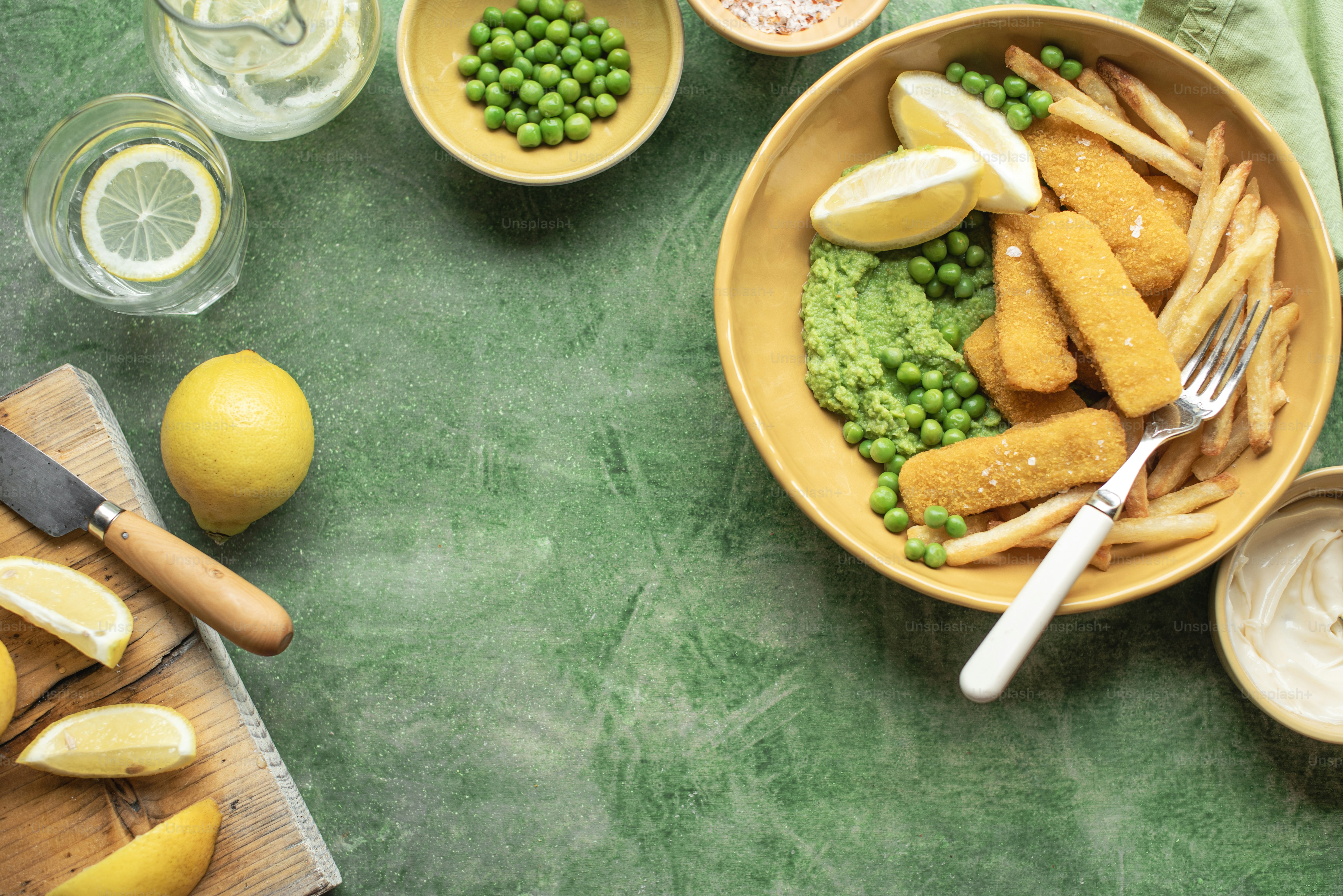 A bowl filled with fish and peas next to lemons photo – Vegan fish ...
