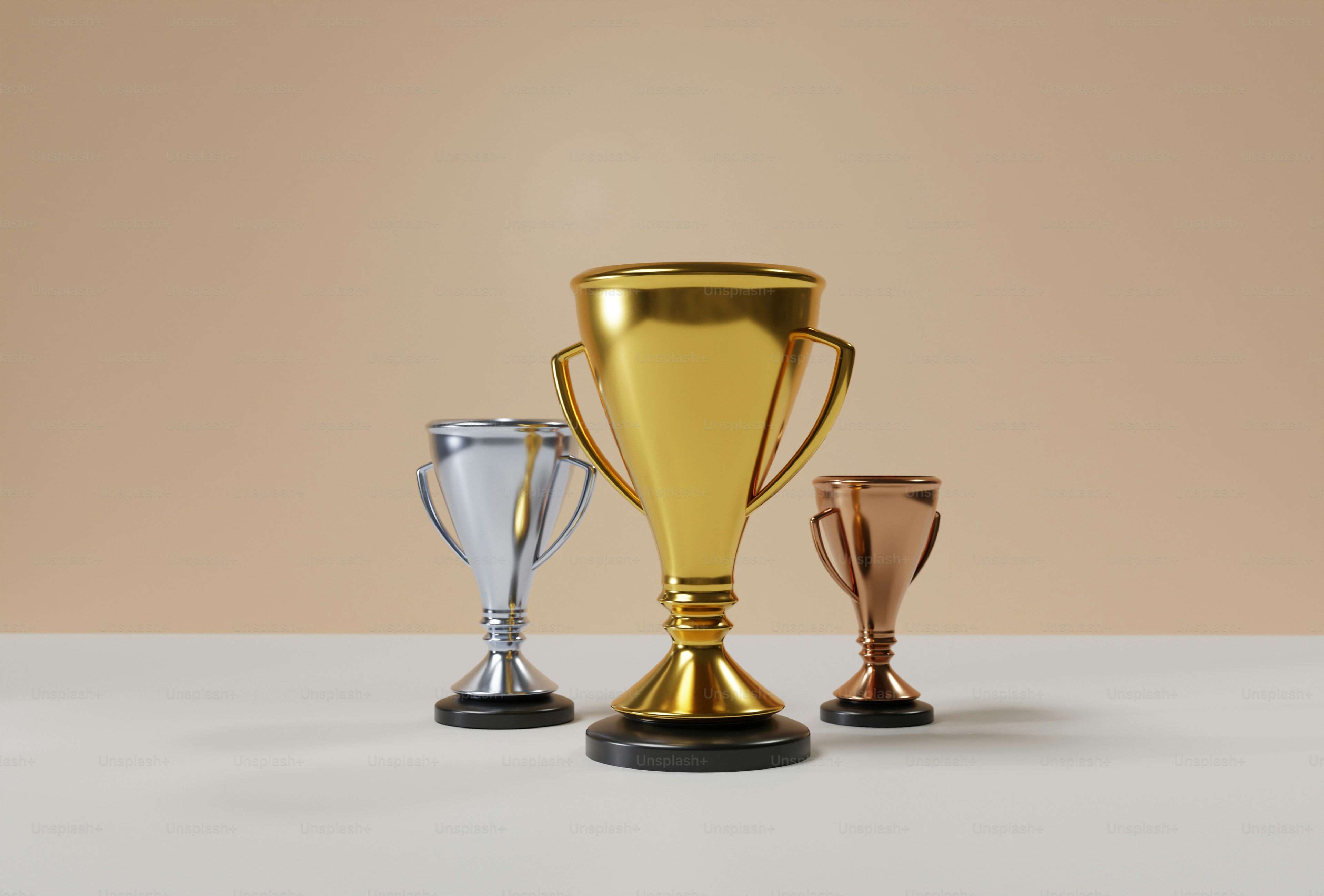 A group of three trophies sitting on top of a table photo – Silver ...