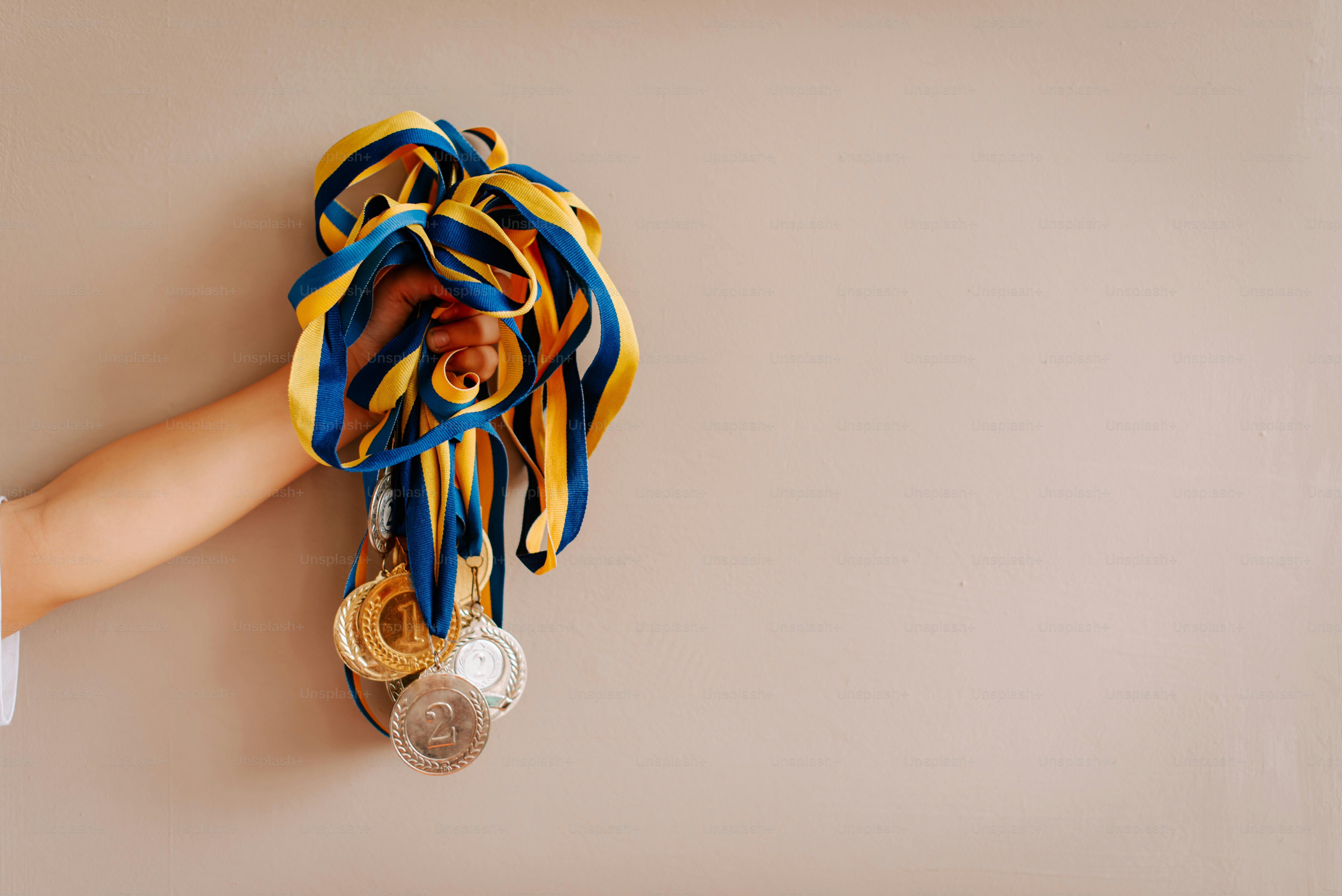 A person holding a medal in their hands photo – Gold medal Image on ...