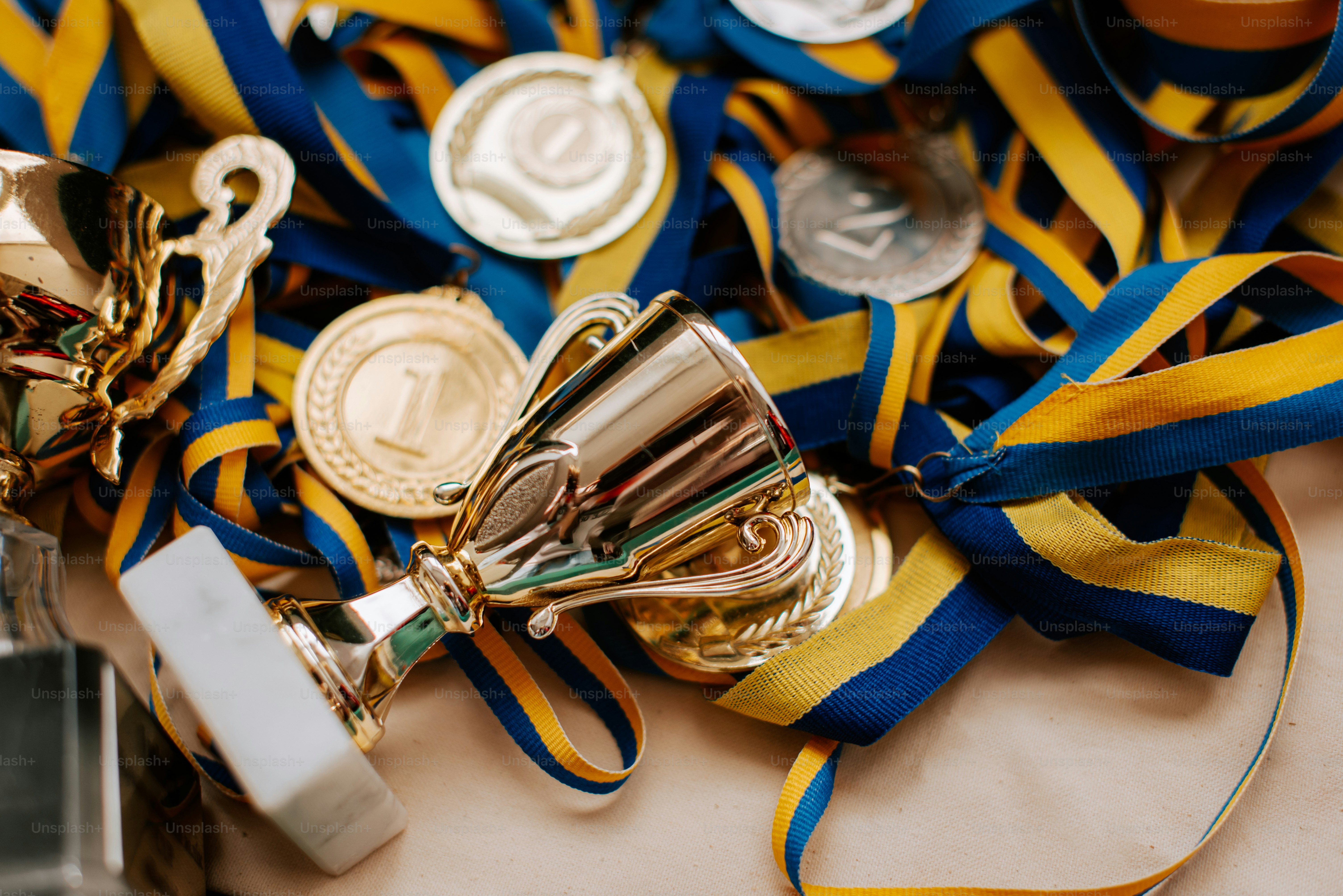 A table topped with lots of trophies and ribbons photo – Trophy Image ...
