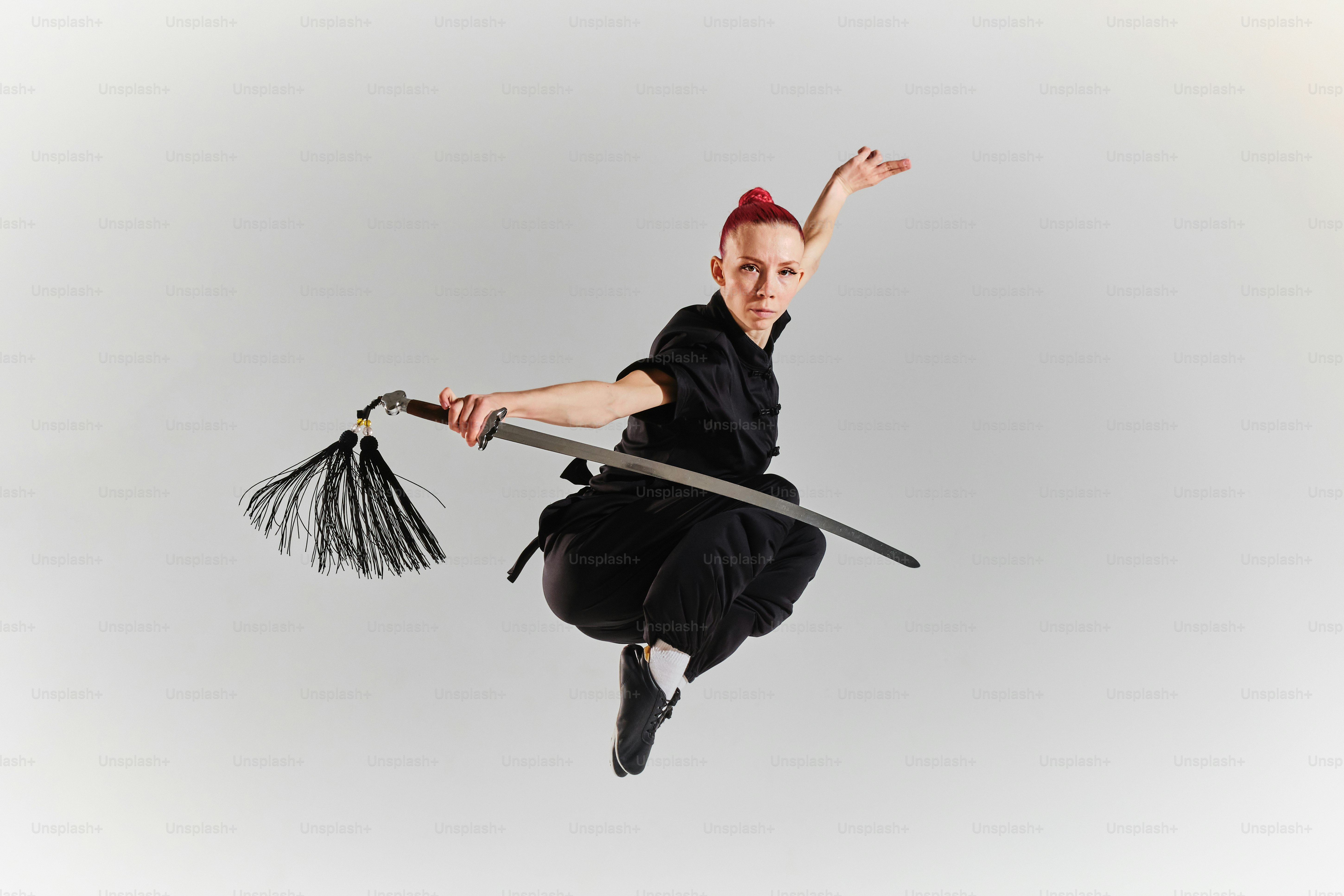 A man flying through the air while holding a sword photo – Wushu Image ...