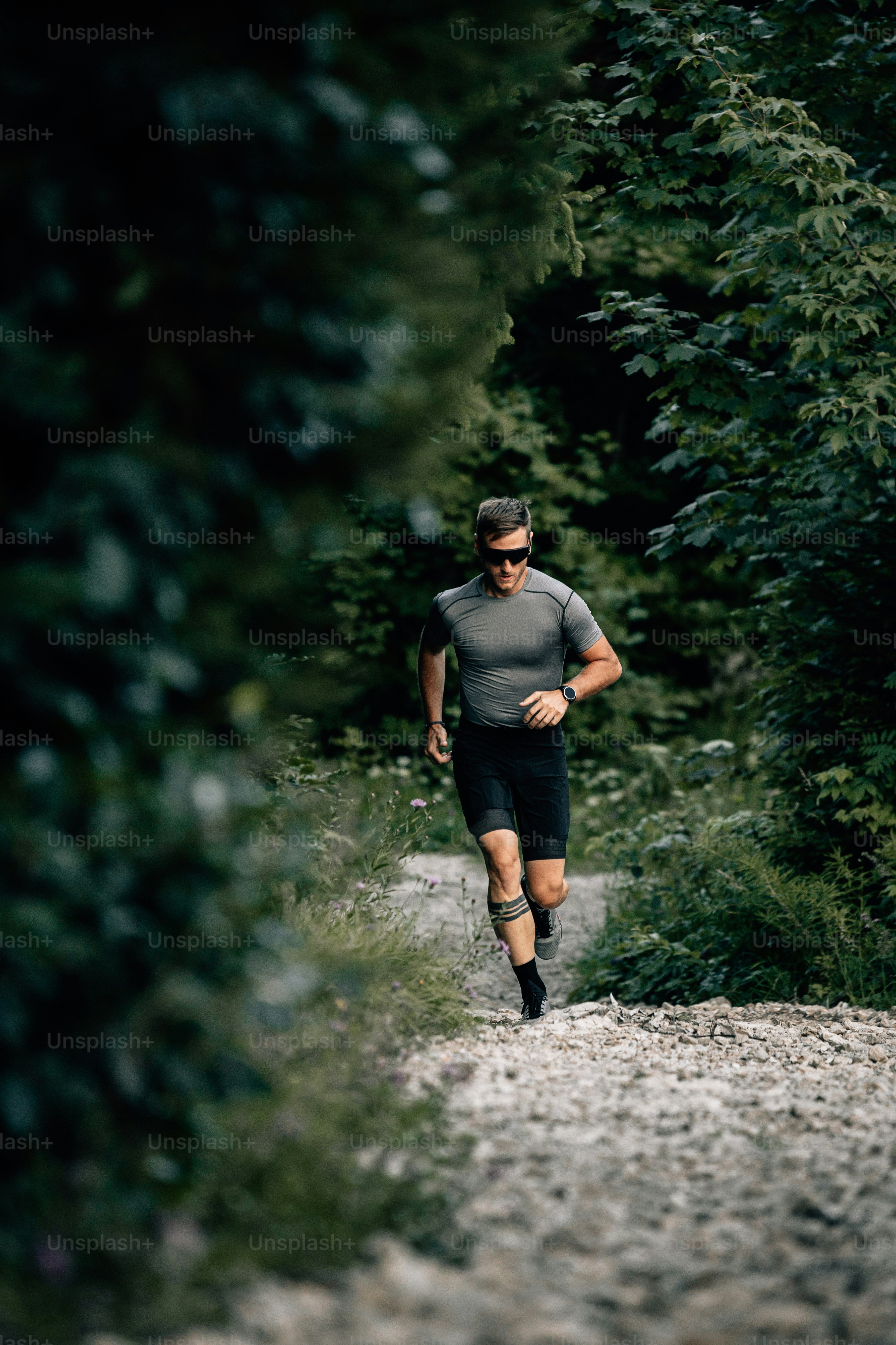 A man running on a trail in the woods photo – Trailrunning Image on ...