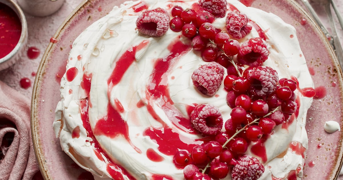 Un Bol De Crème Fouettée Avec Des Framboises Sur Le Dessus Photo