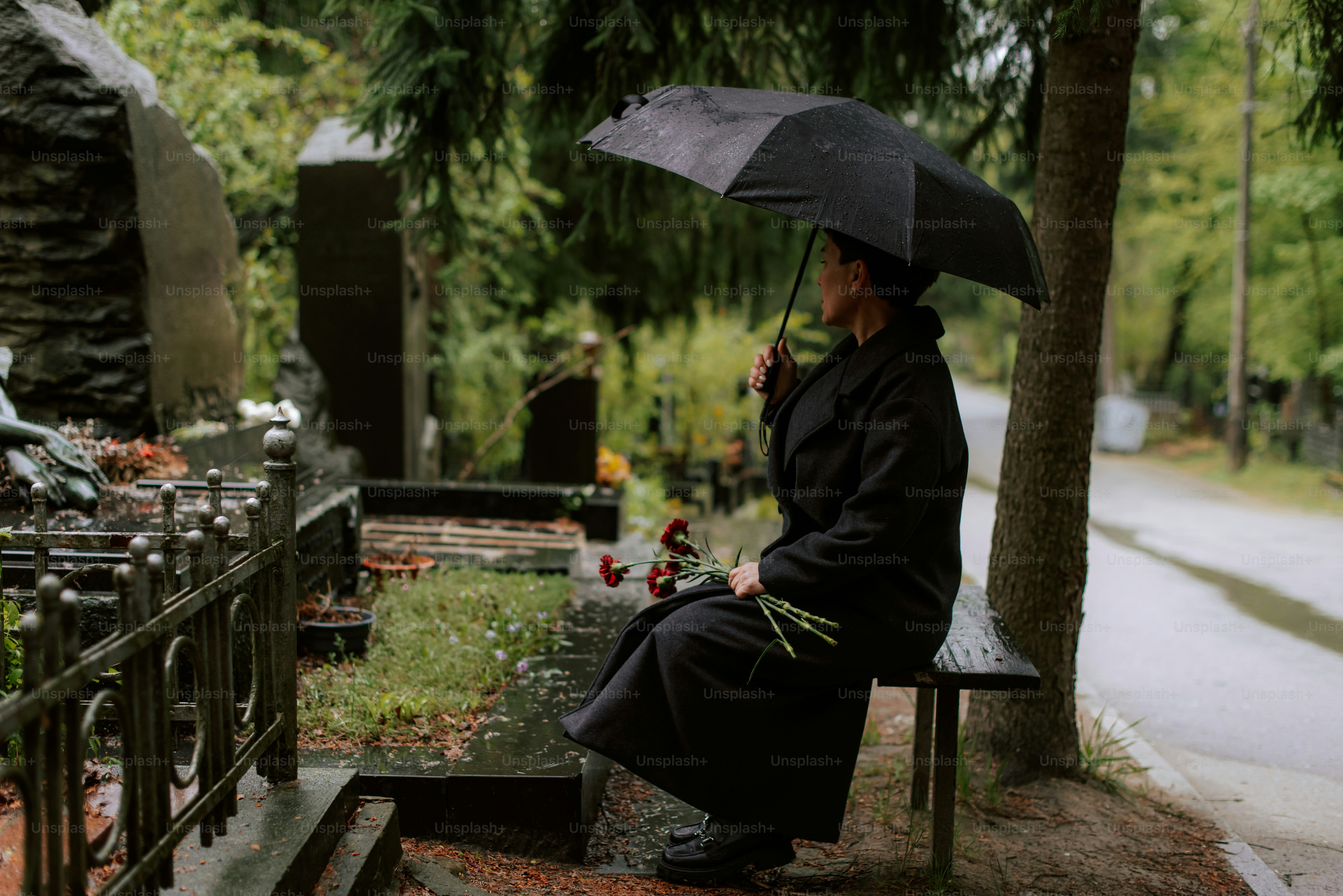 A person sitting on a bench with an umbrella photo – Funeral Image on ...