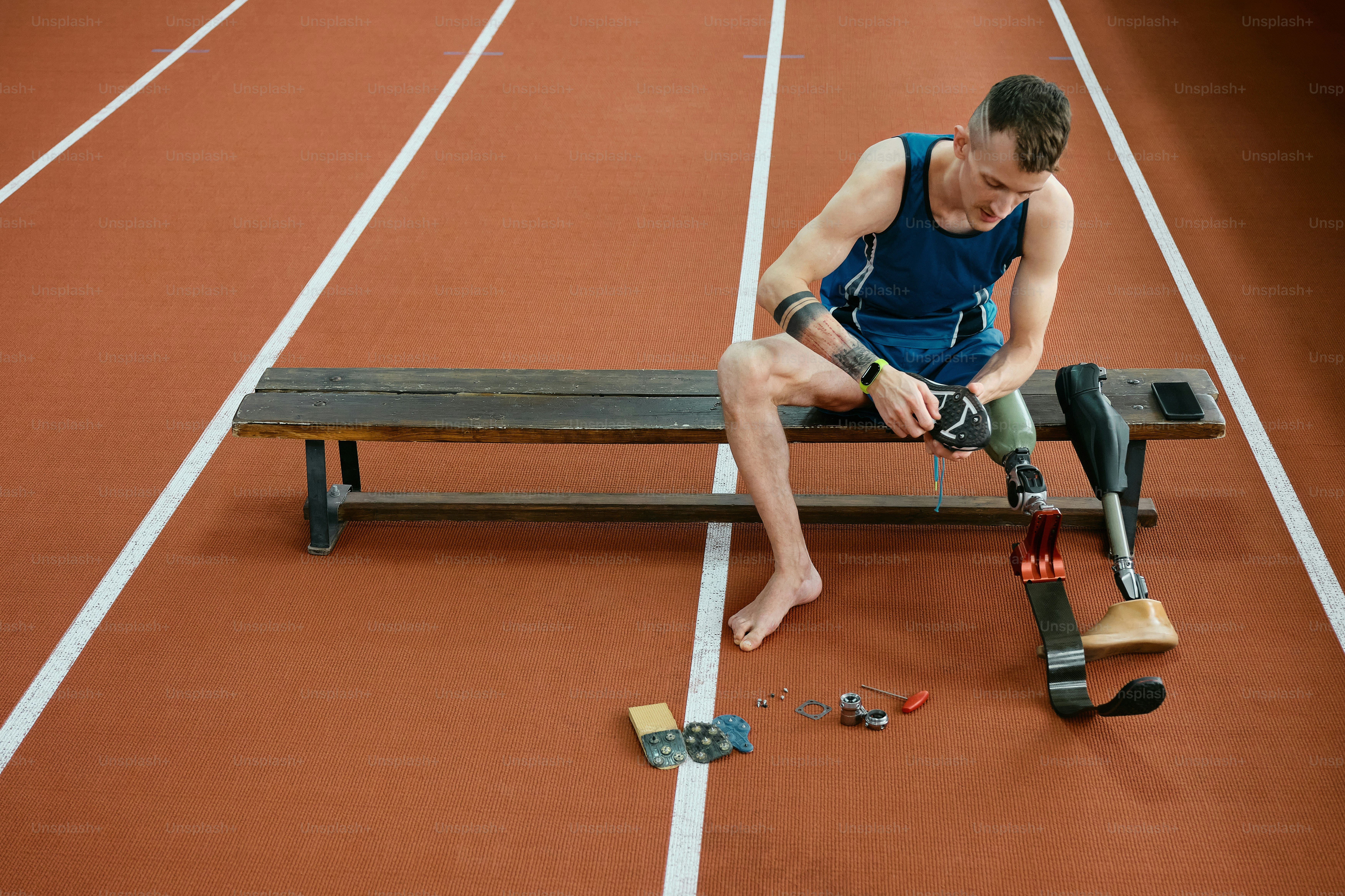 A man sitting on a bench with a broken leg photo – Amputee athlete ...