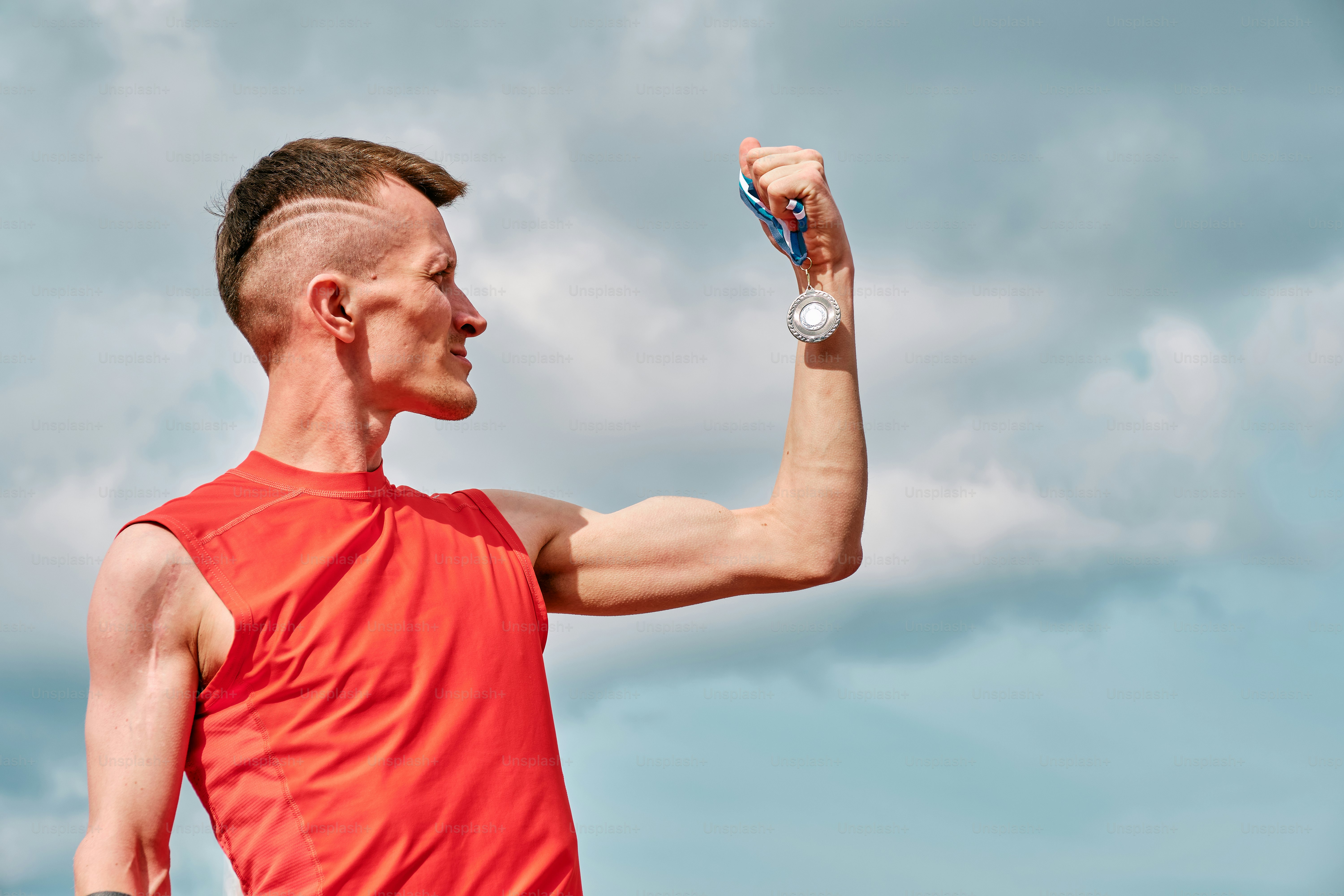 A man holding a medal and a medal in his hand photo – Paralympic Image ...