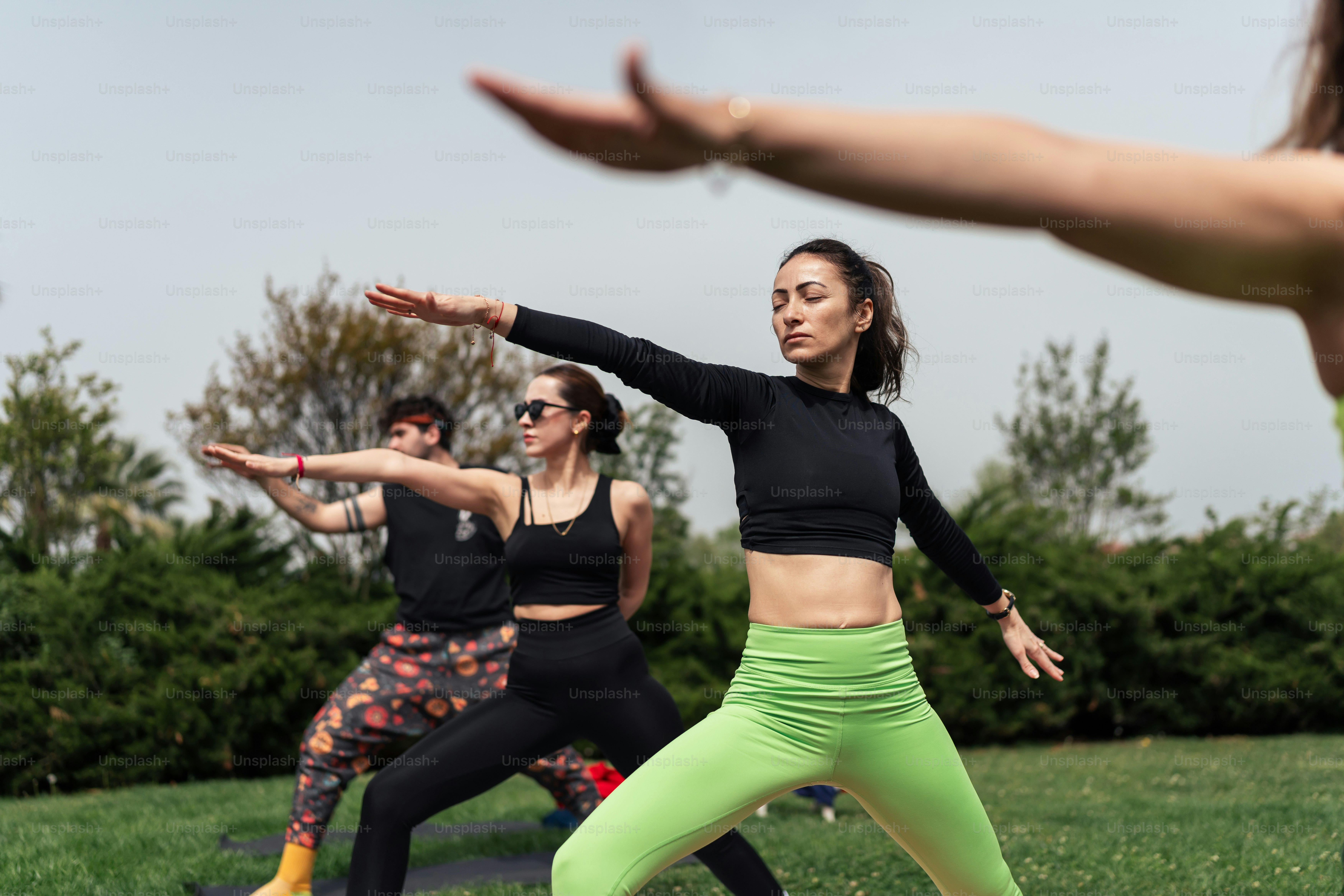 A group of people in a park doing yoga photo – Wellness retreat Image ...