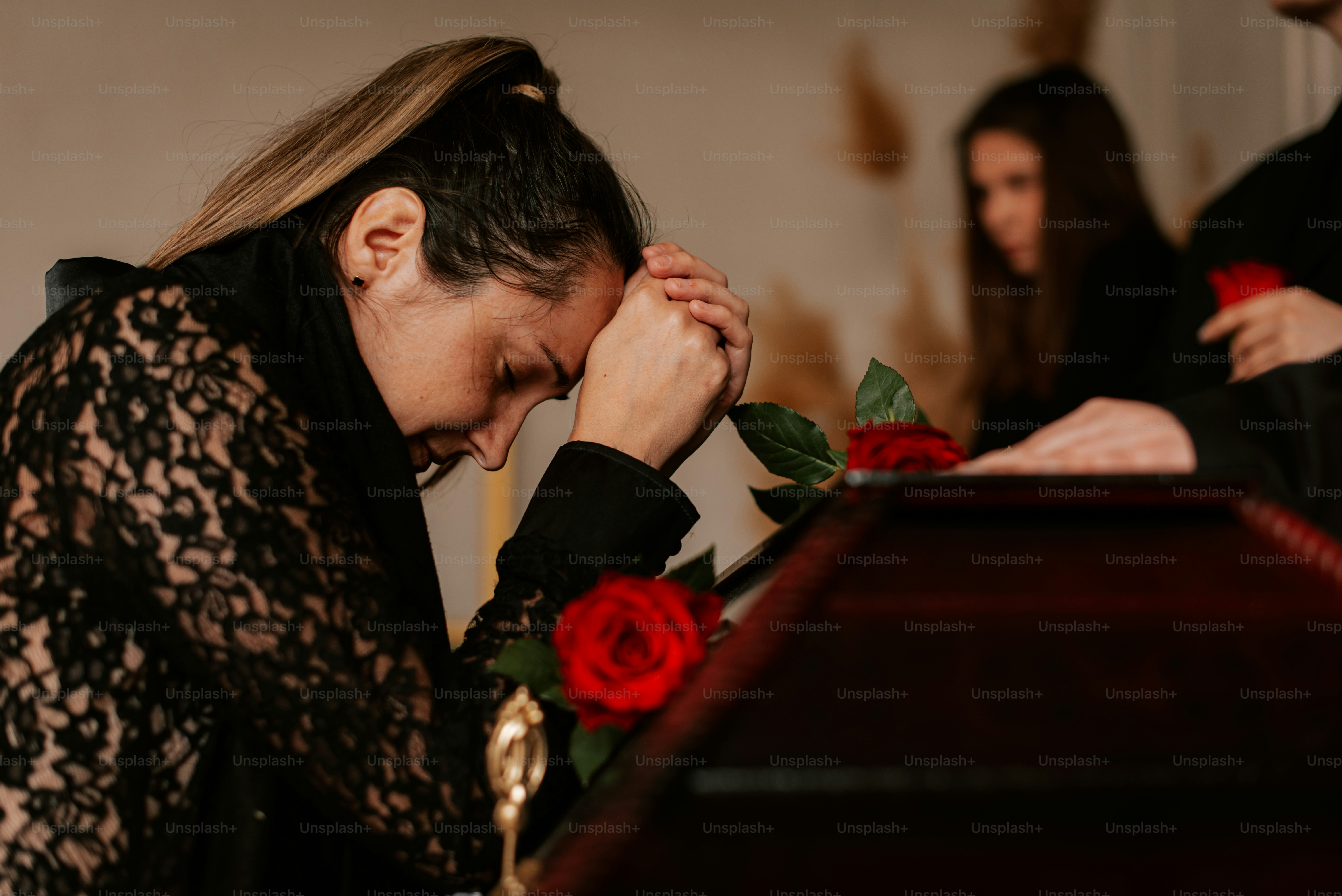 A woman sitting at a piano with her hands on her face photo – Funeral ...