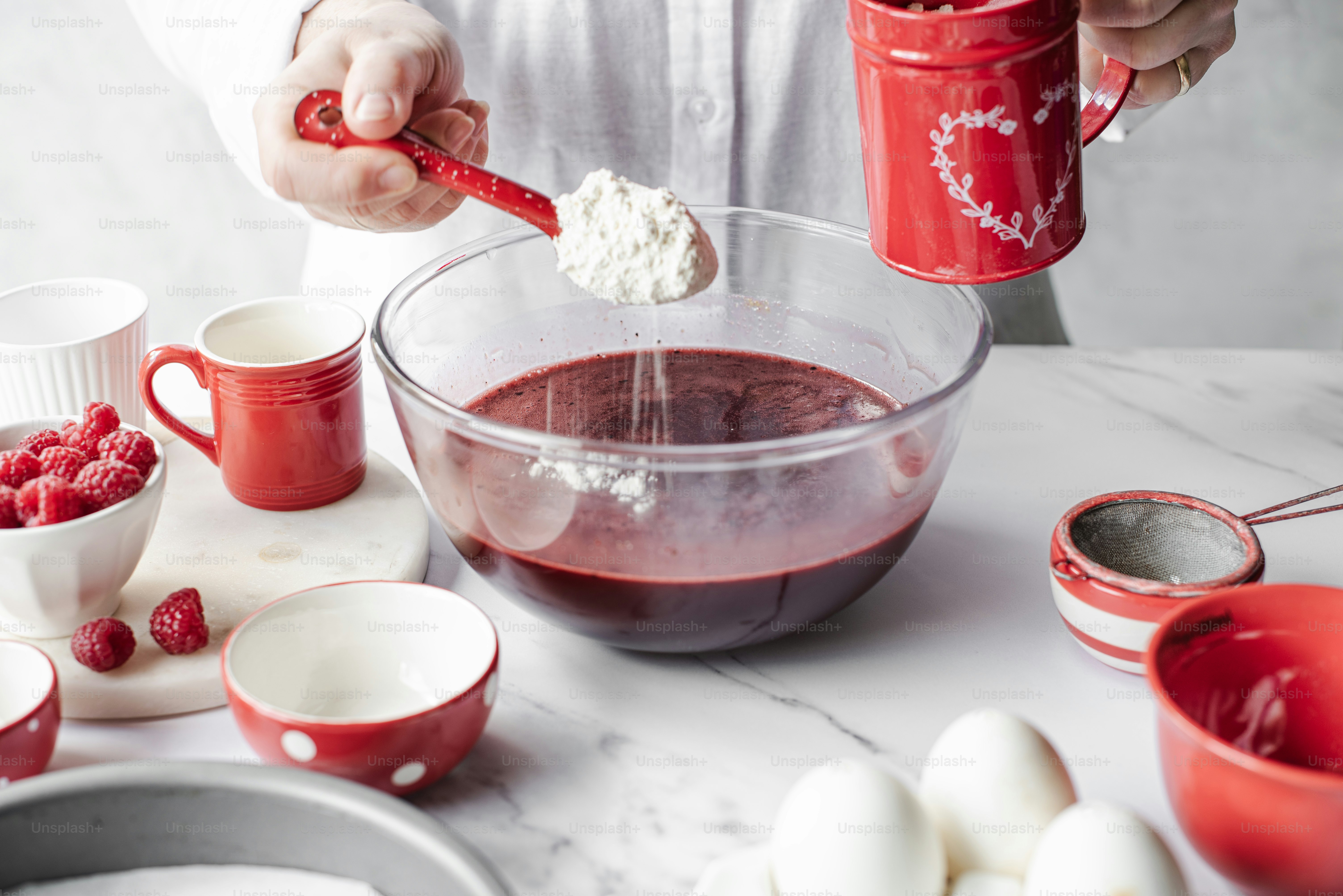 A person mixing ingredients in a bowl on a table photo – Food preparing ...