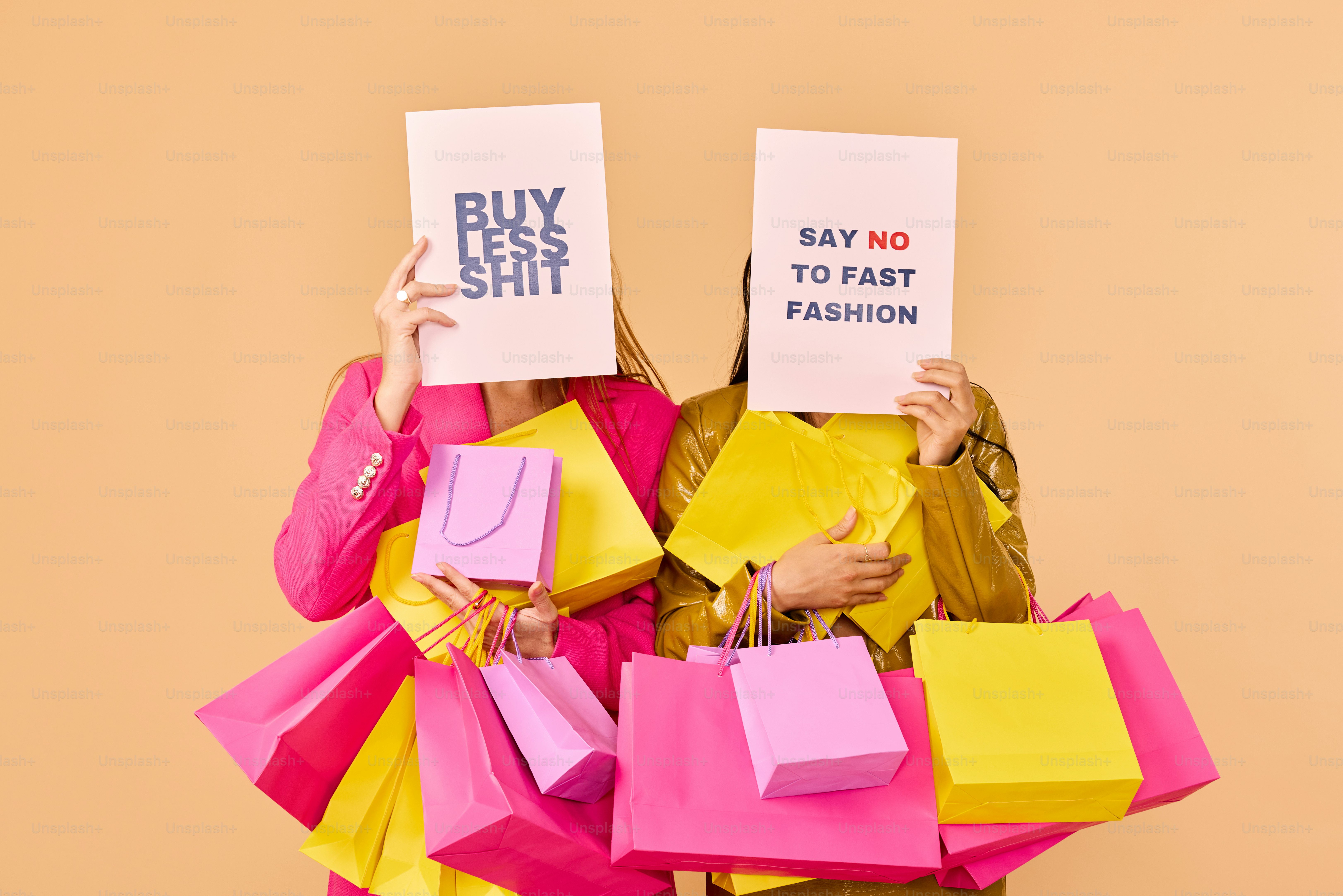 Two women holding signs that say say no to fast fashion photo ...