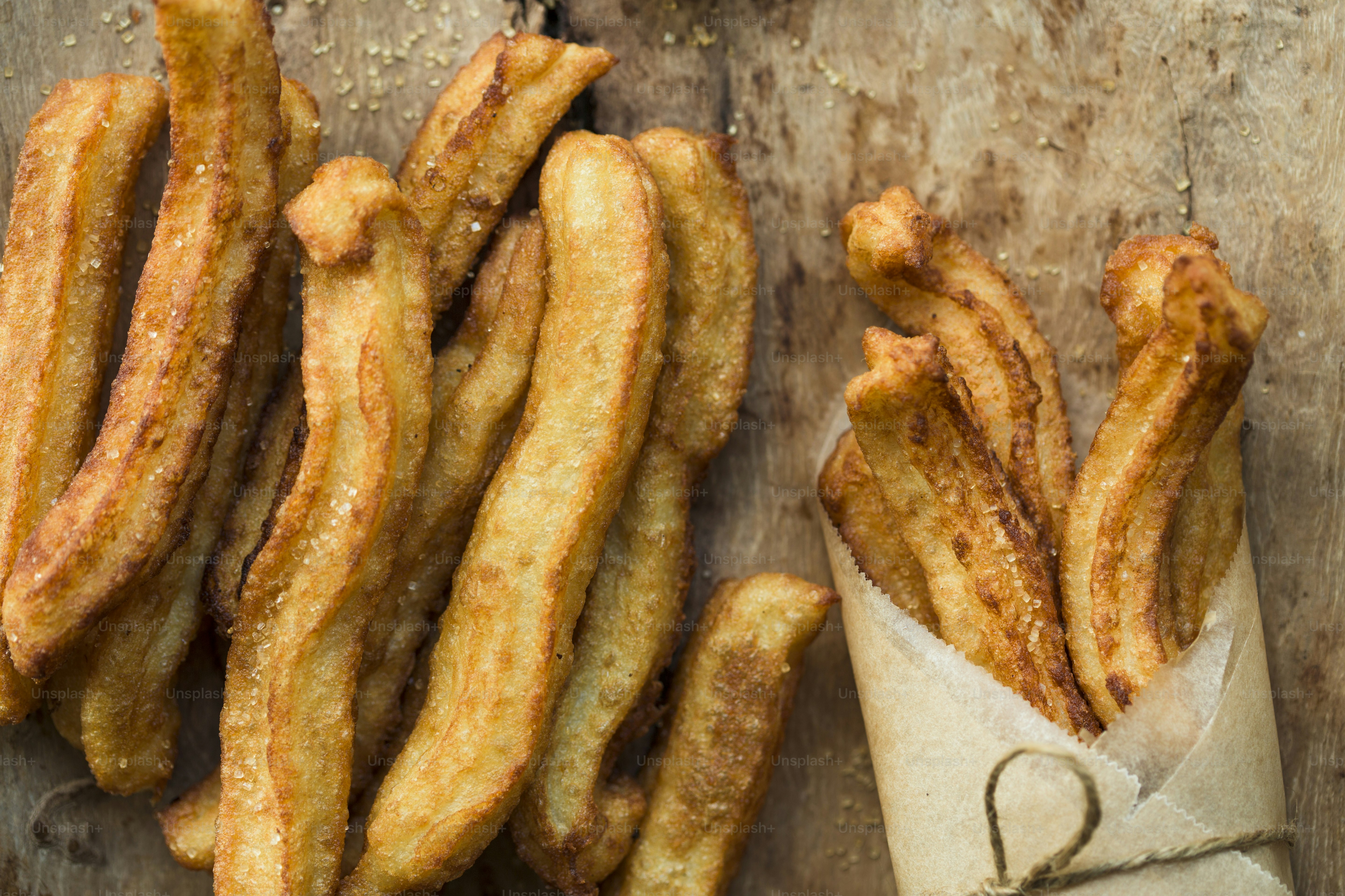 A bunch of french fries sitting on top of a wooden table photo ...