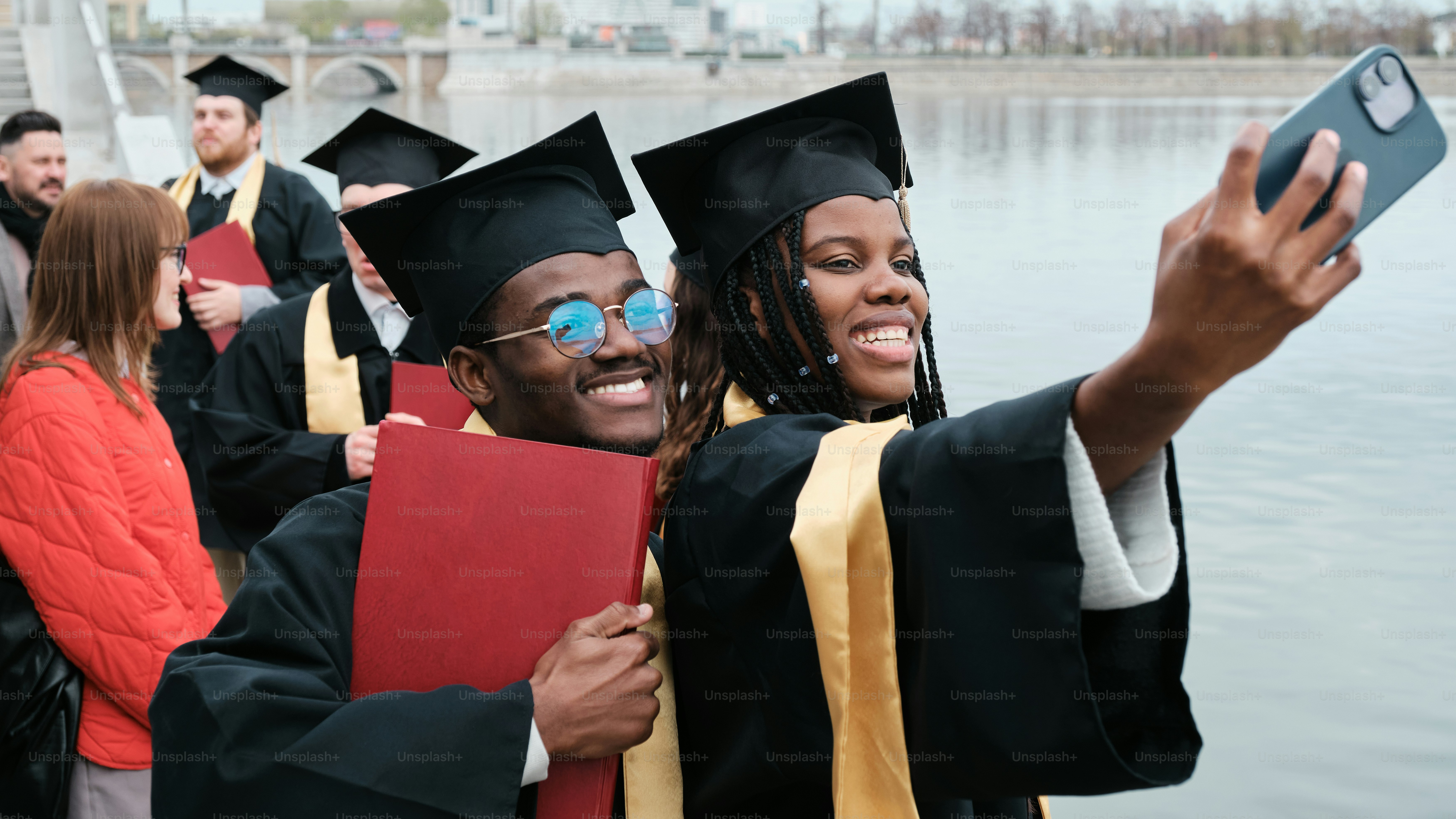 A group of graduates taking a picture with their cell phone photo ...