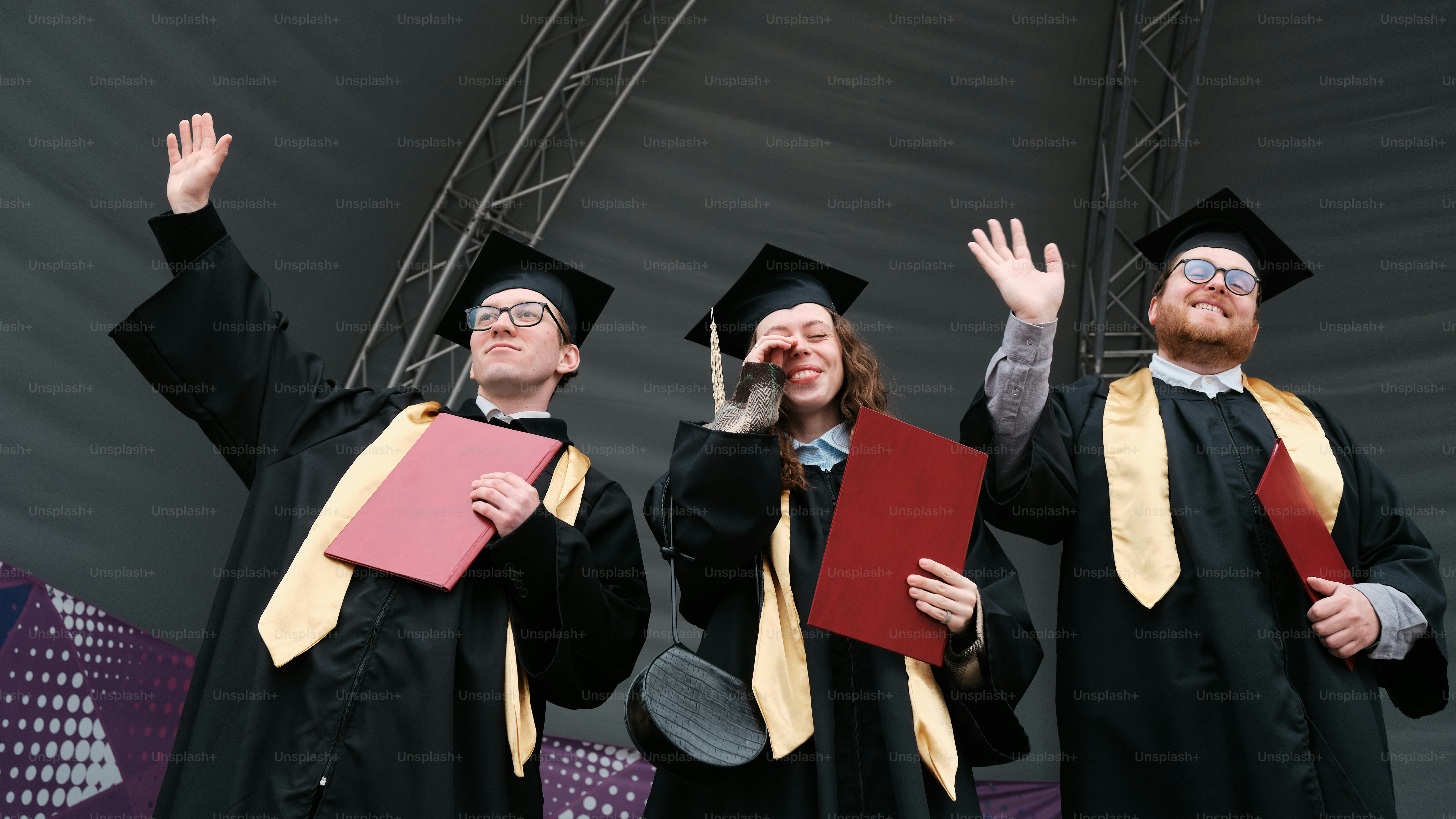 A group of people in graduation gowns standing on a stage photo ...