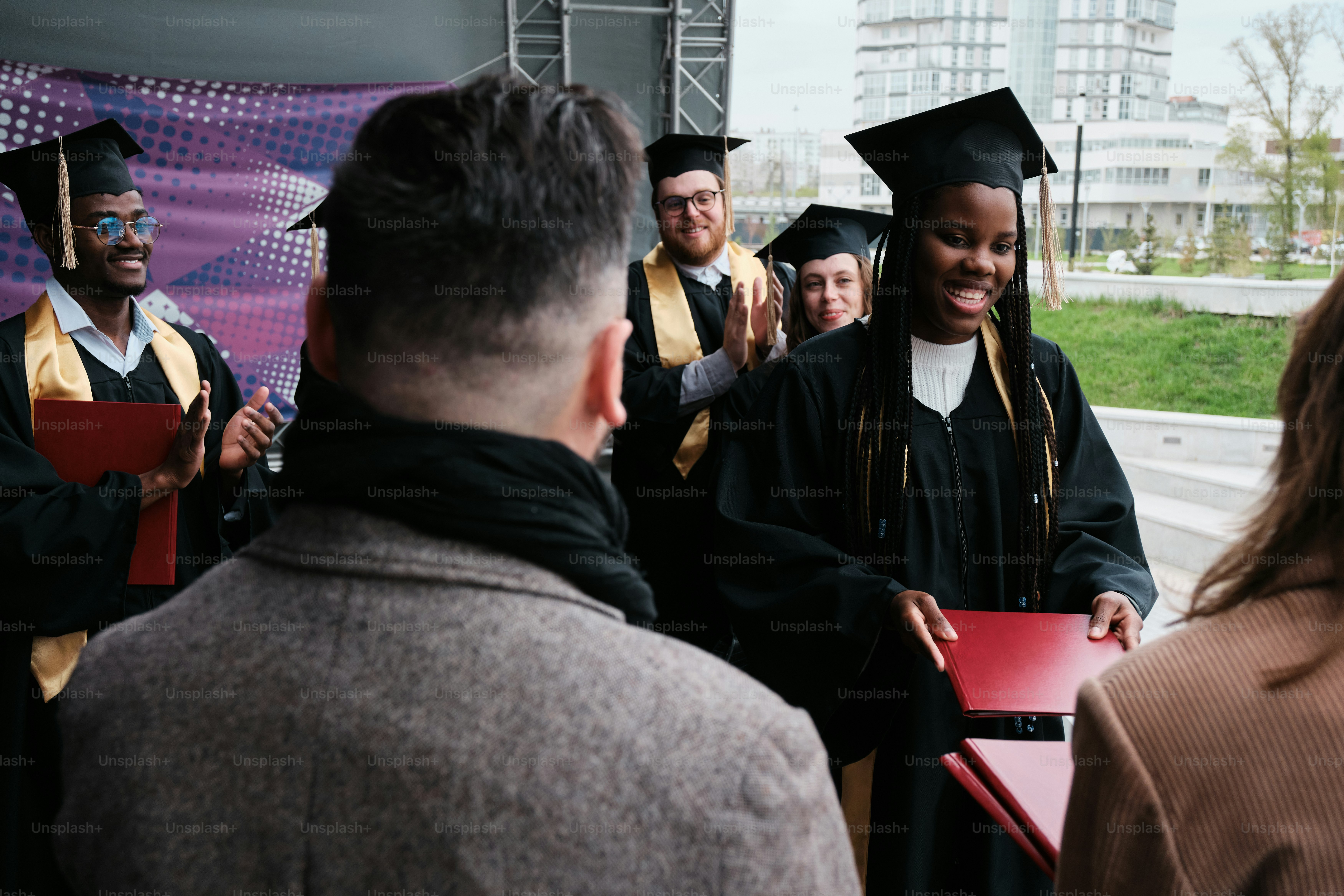 A group of people in graduation gowns standing on a stage photo ...