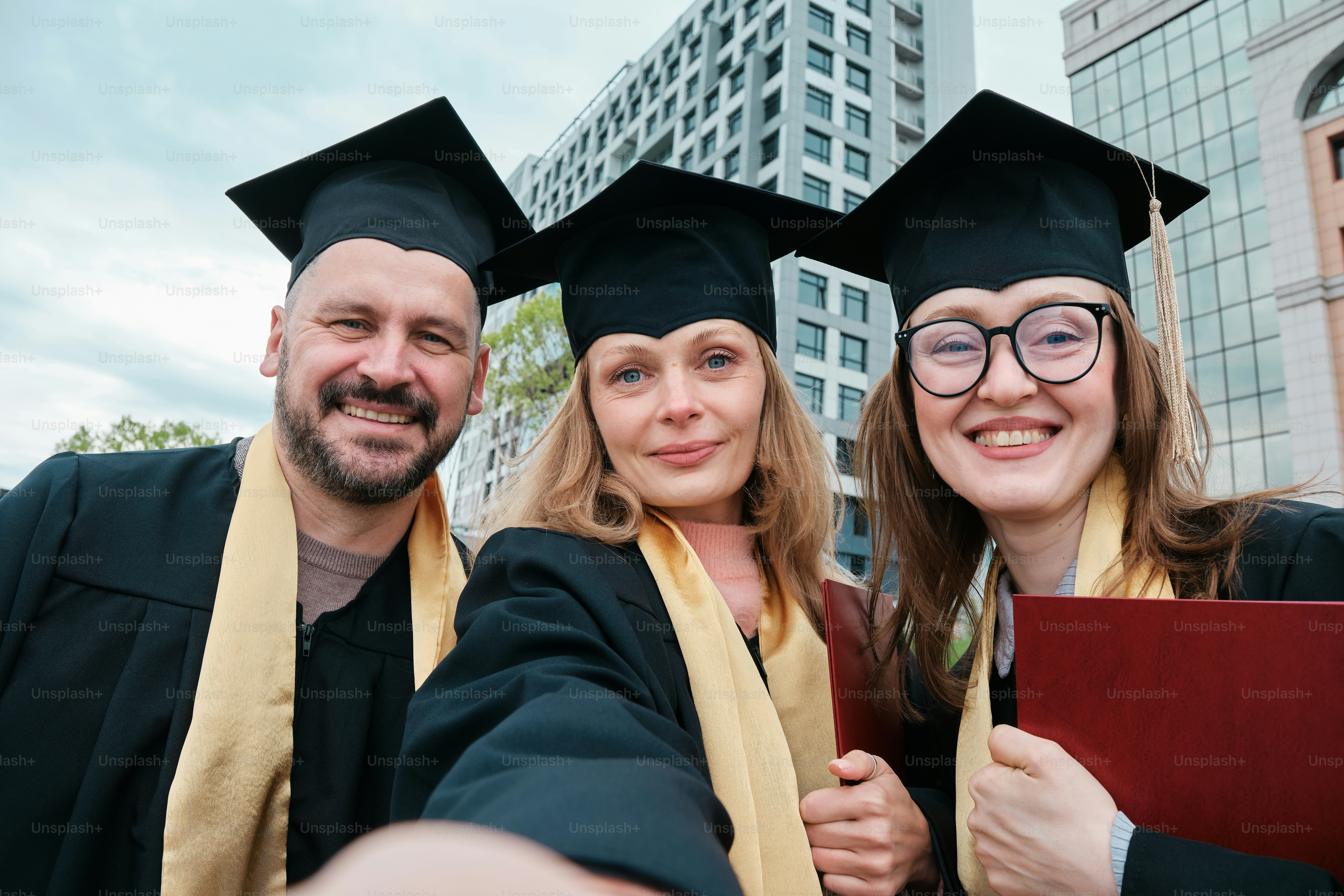 A group of people in graduation gowns taking a selfie photo – Students ...