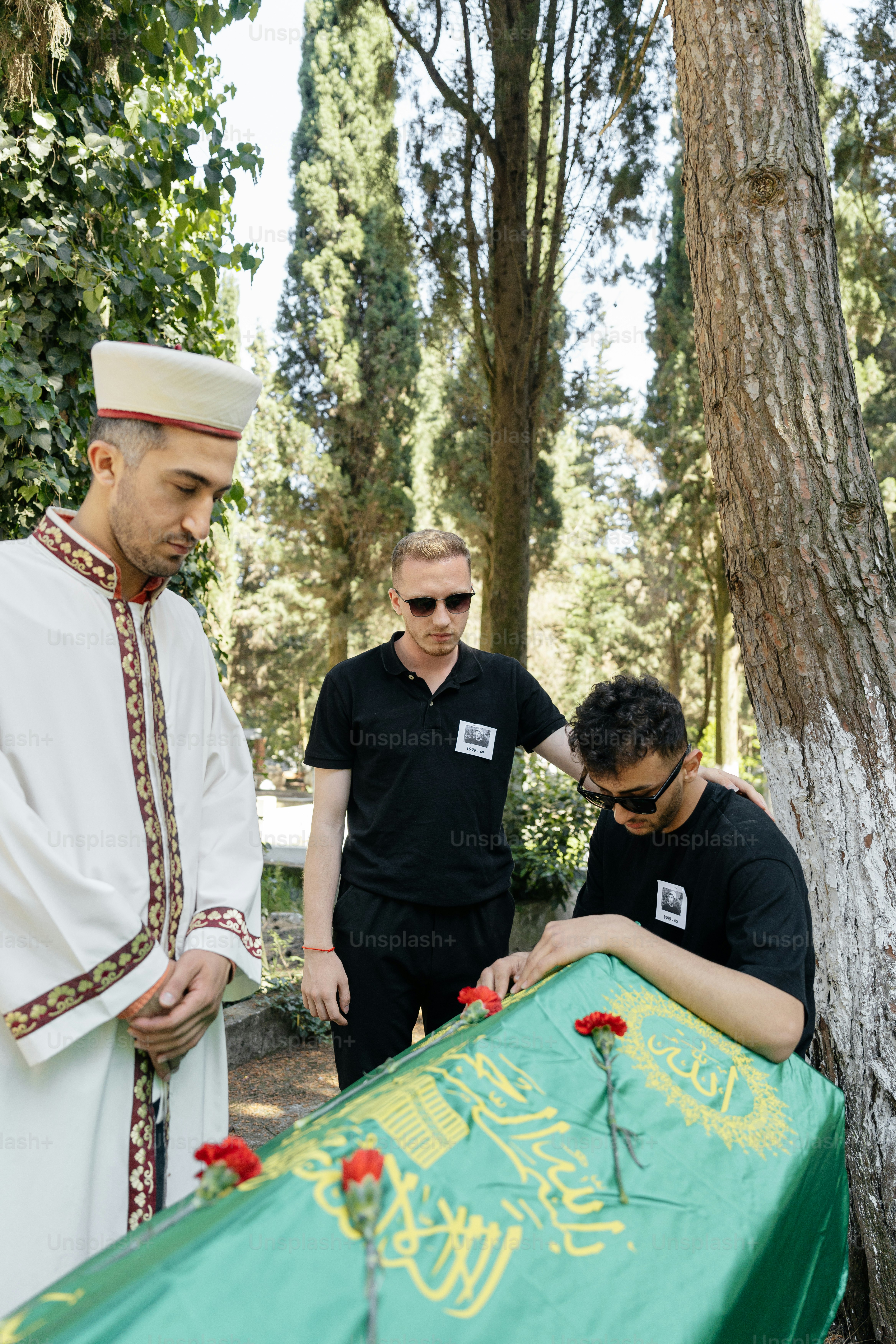 A group of men standing around a green table photo – Grieving Image on ...