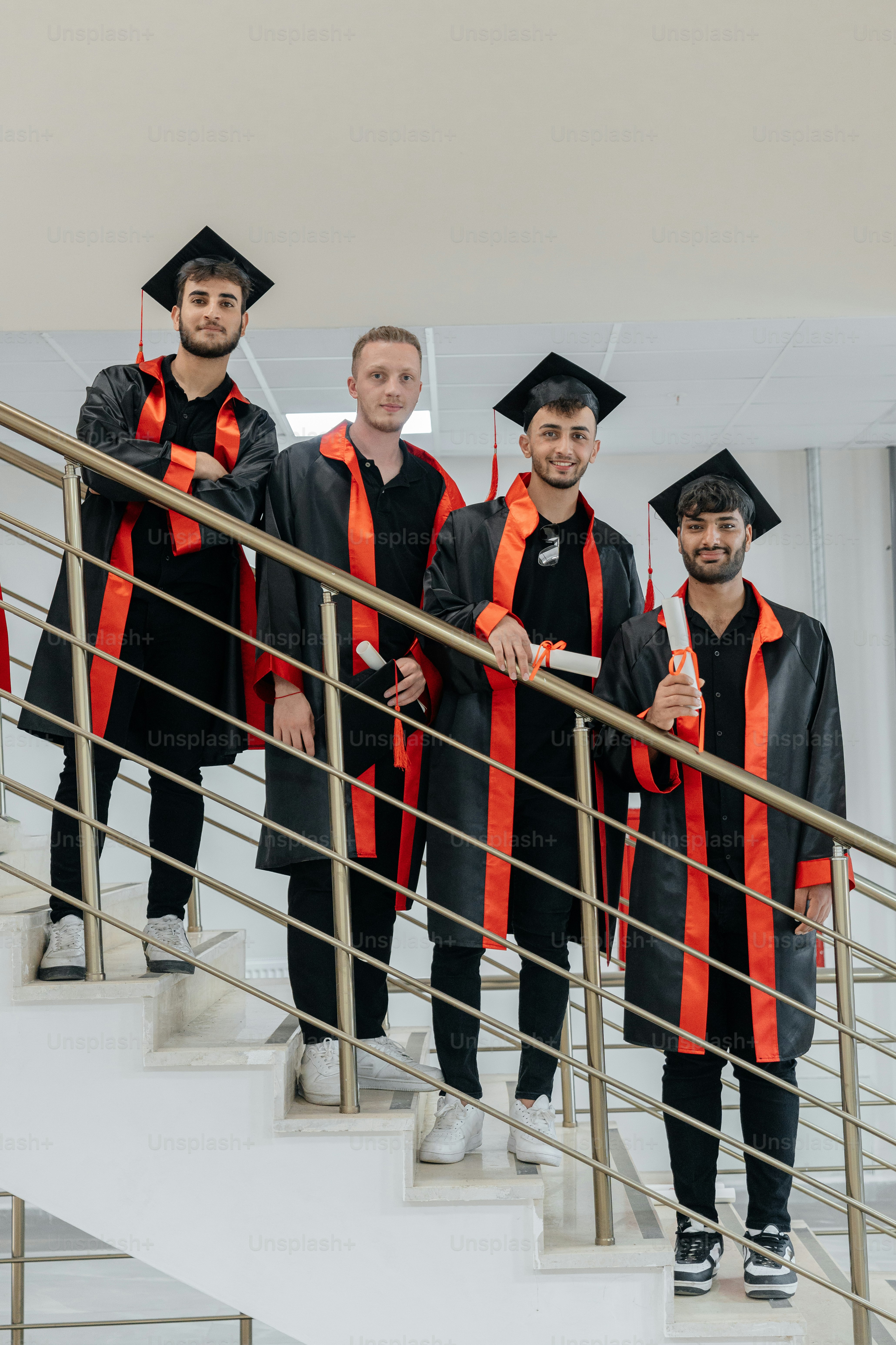 A group of men standing on top of a stair case photo – College ...