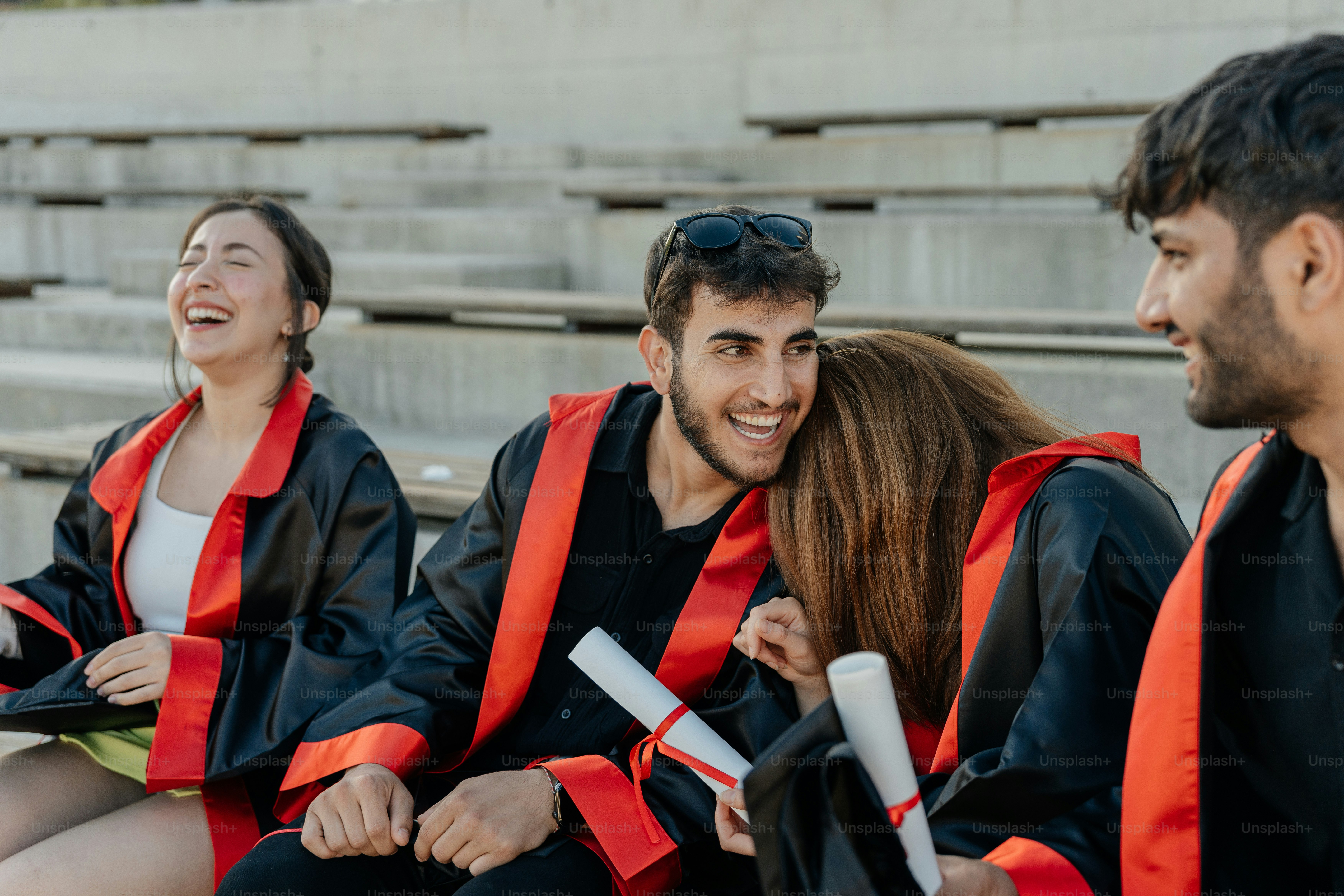 A group of young people sitting next to each other photo – Graduation ...