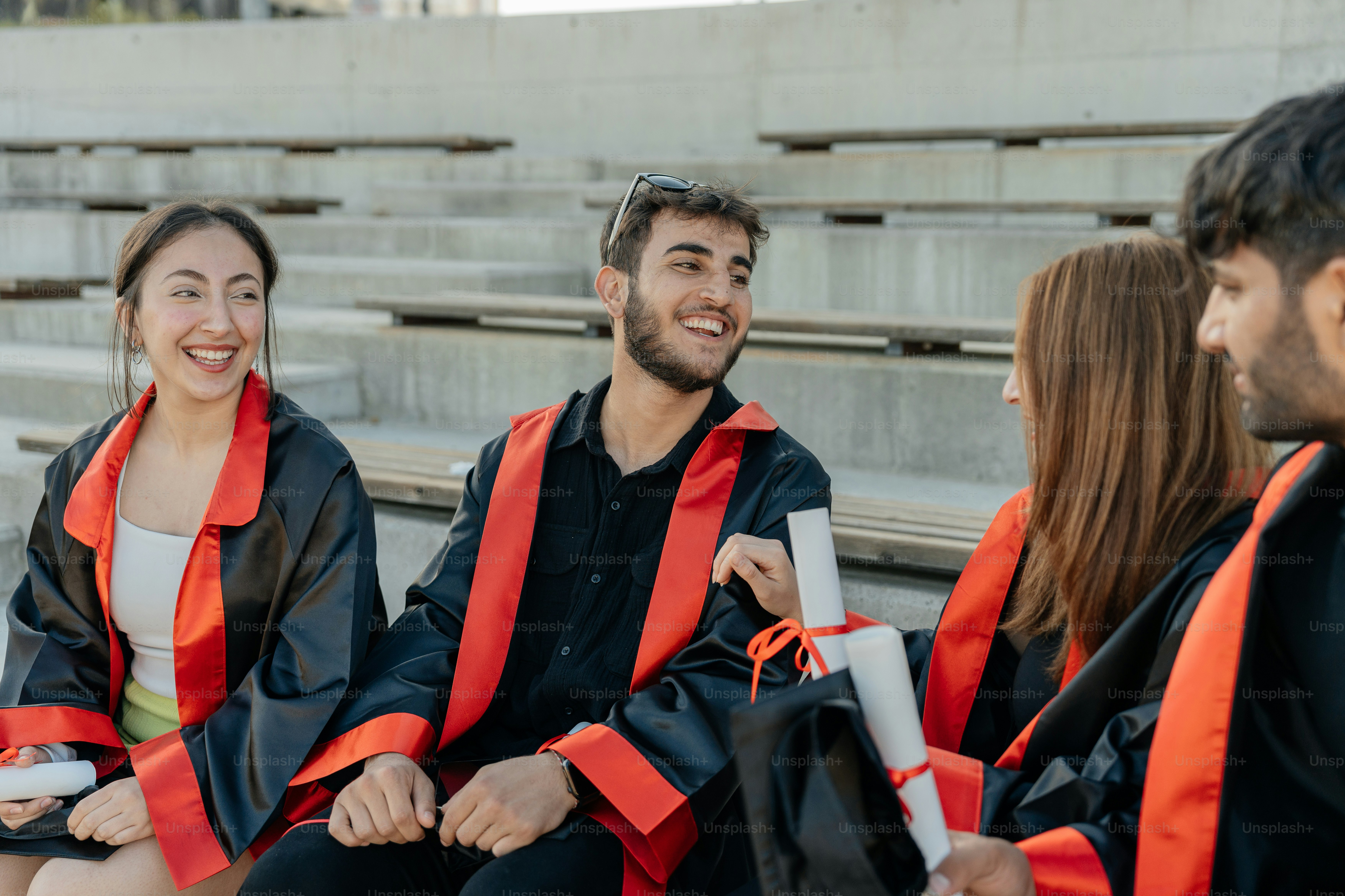A group of graduates sitting on the bleachers photo – Graduation Image ...