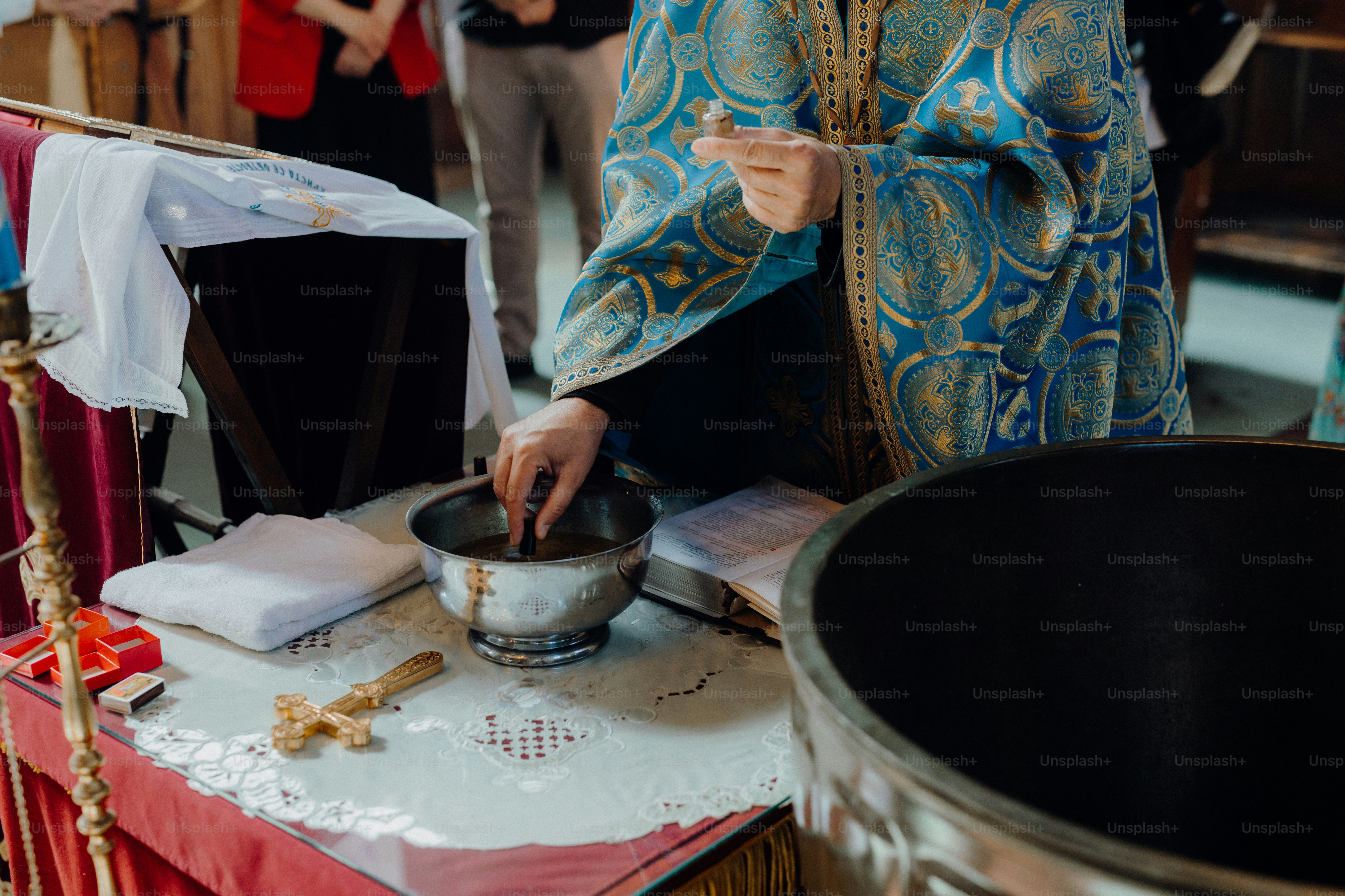 A priest stirring a bowl of food on a table photo – Christian lifestyle ...