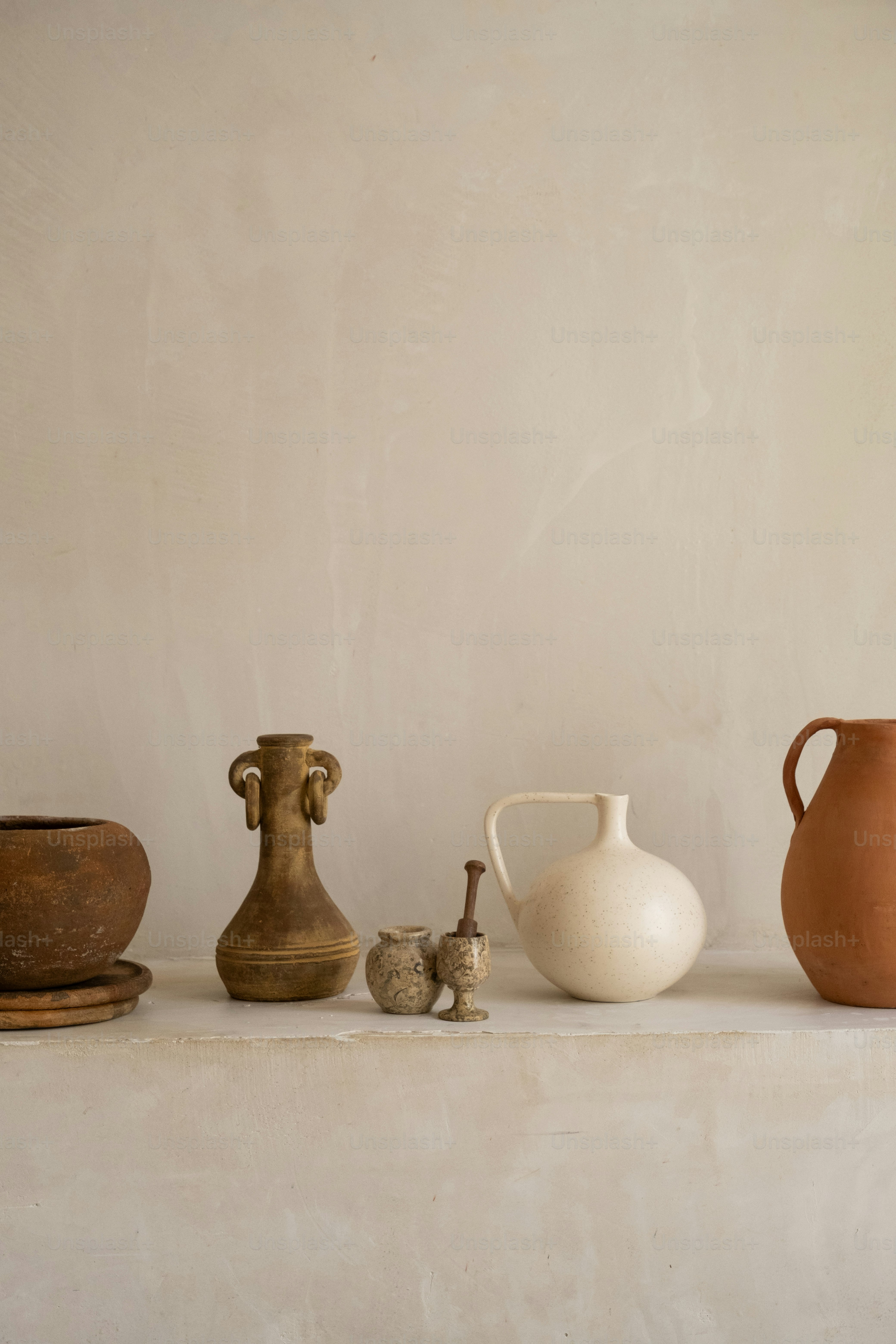 A group of vases sitting on top of a table photo – Pestle and mortar ...