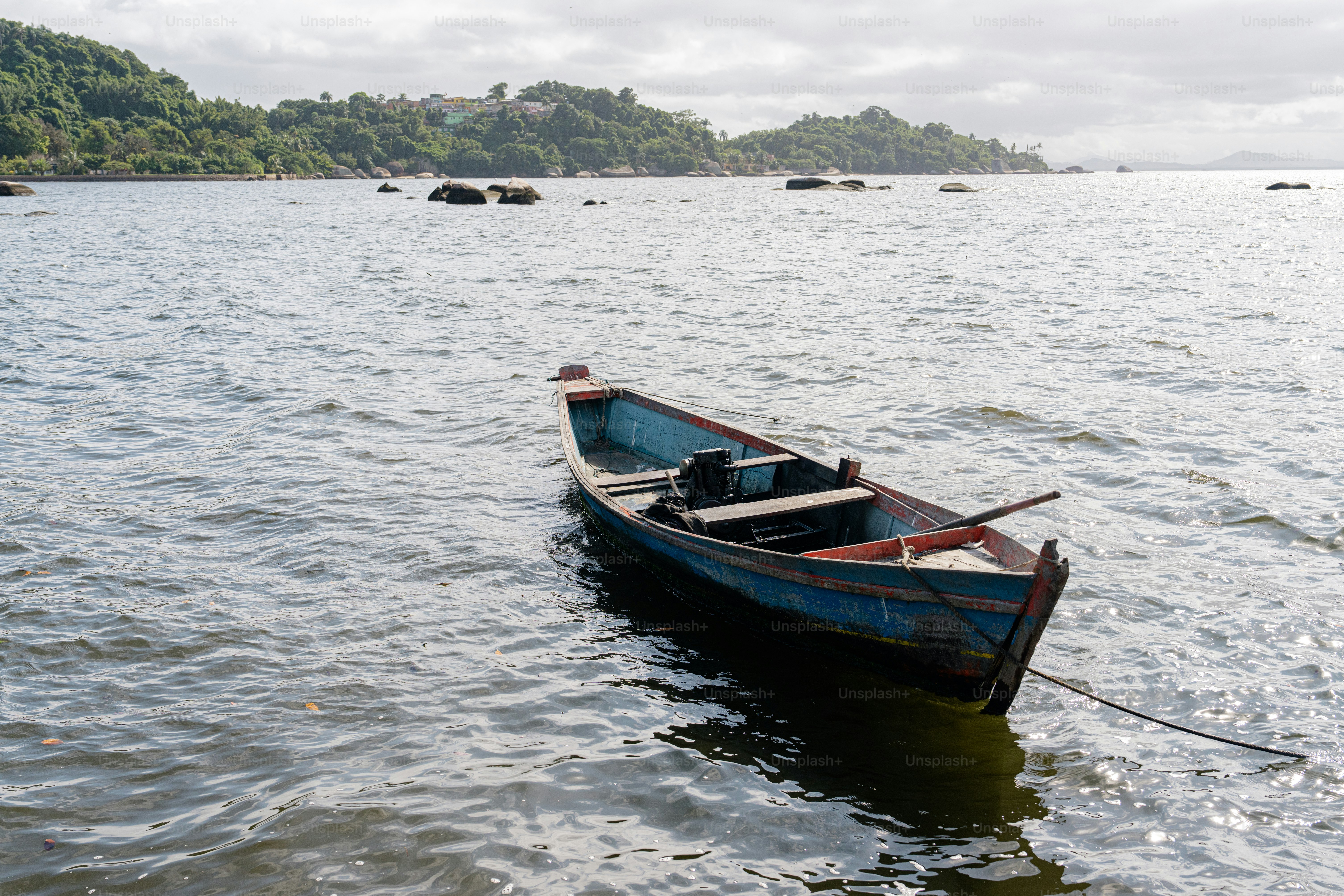 A small blue boat floating on top of a lake photo – Vacation Image on ...
