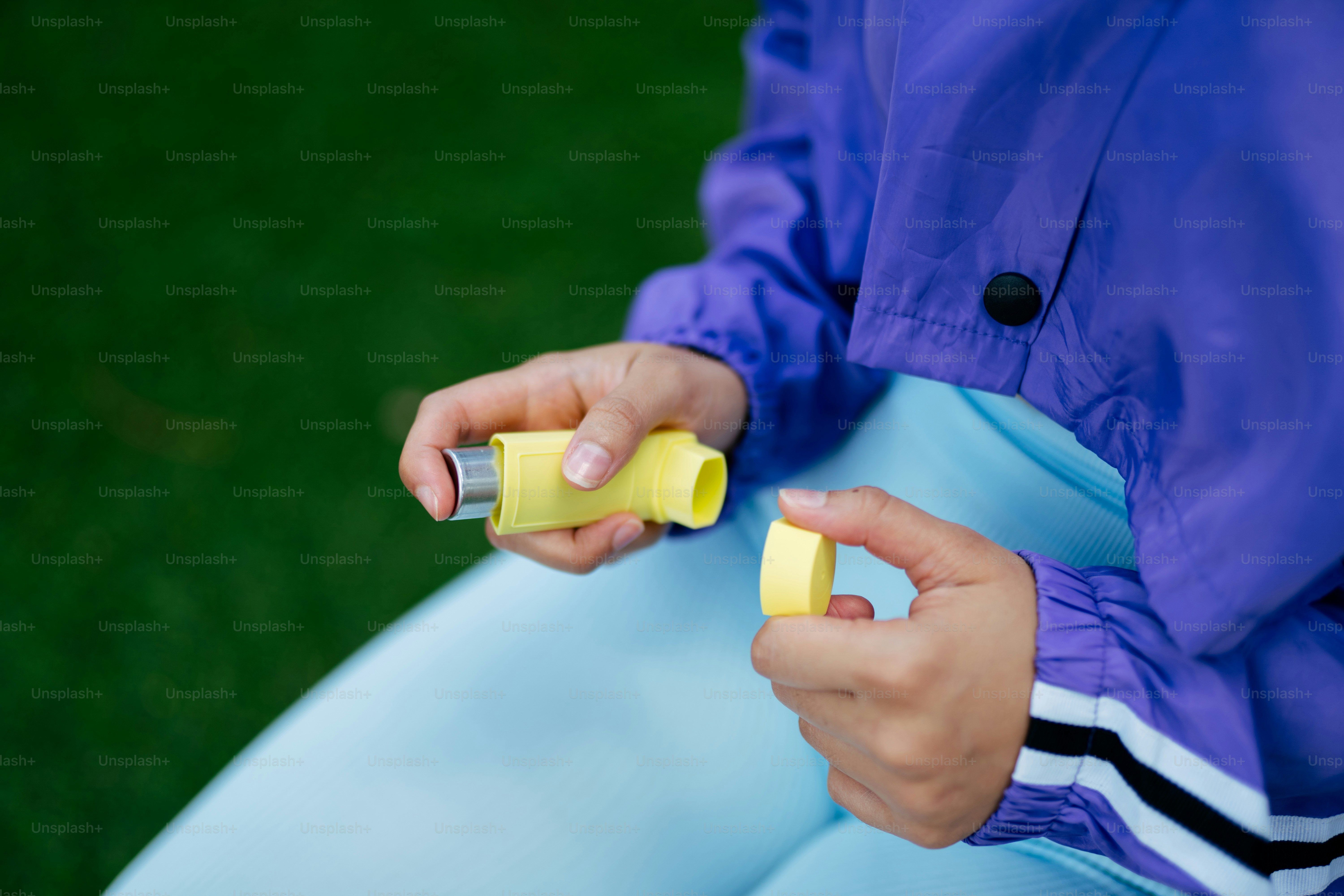 A person sitting on a bench with a yellow object in their hand photo ...
