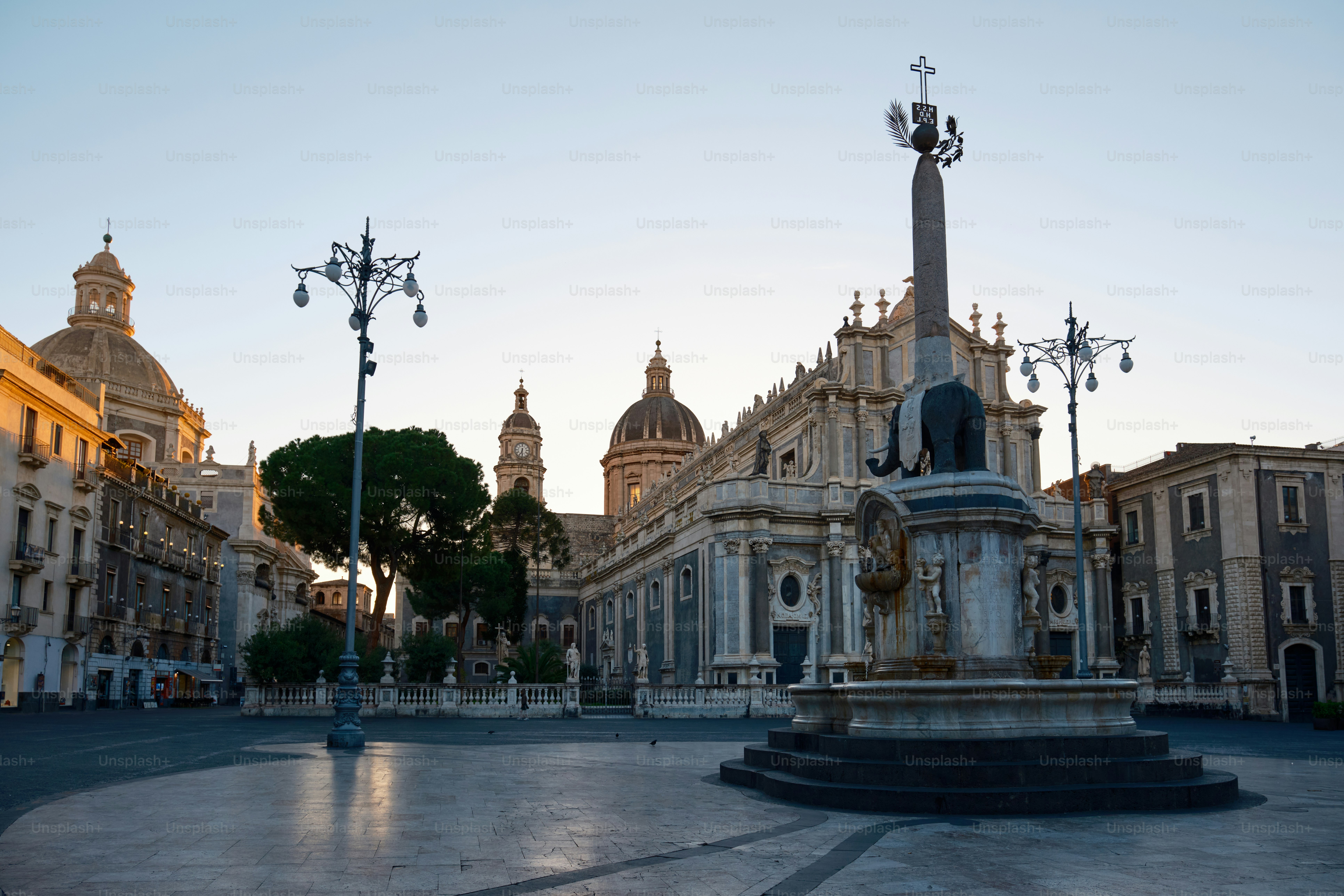 A city square with a statue in the middle of it photo – Italy Image on ...