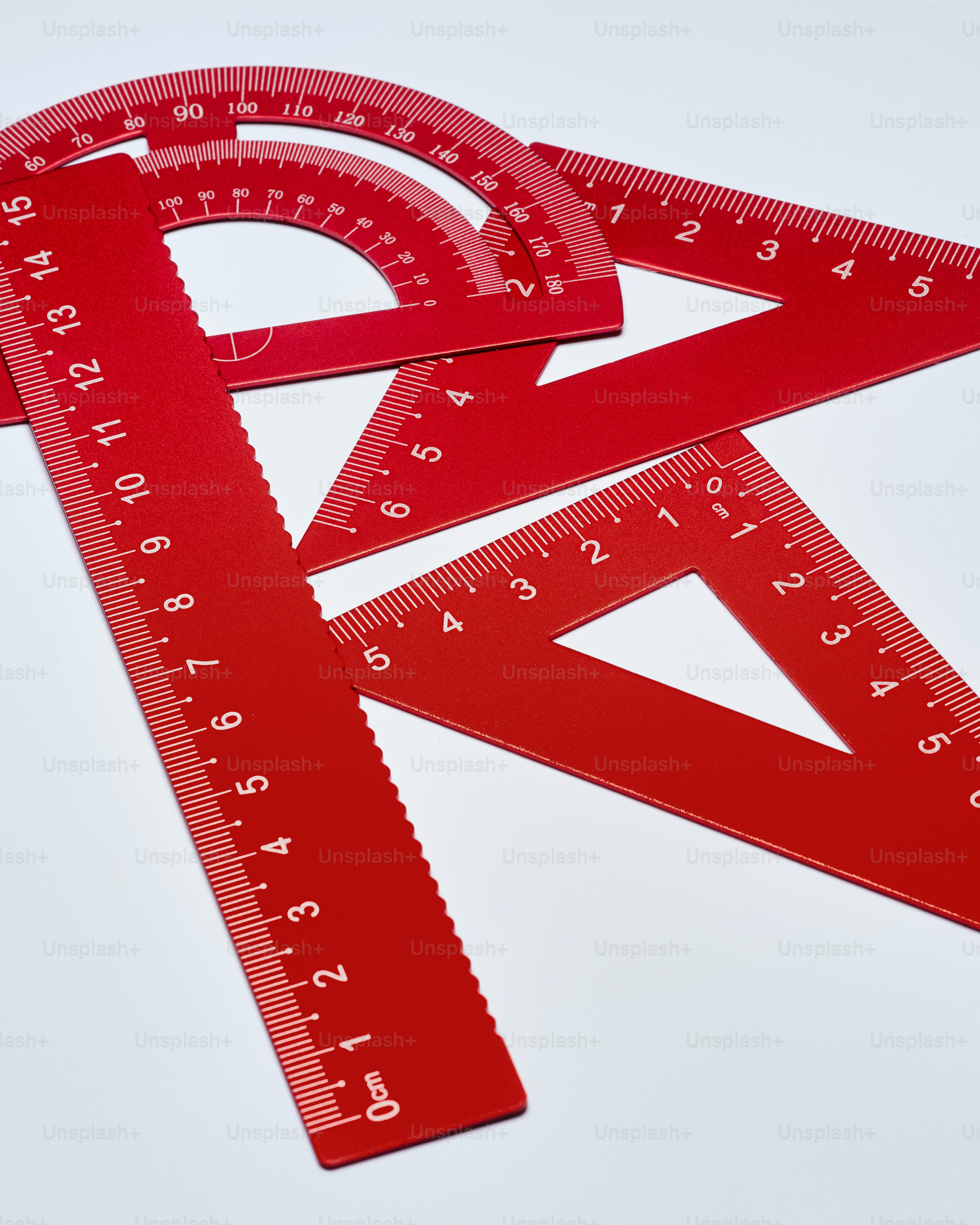 A pair of red rulers with a ruler on top of them photo – School Image ...