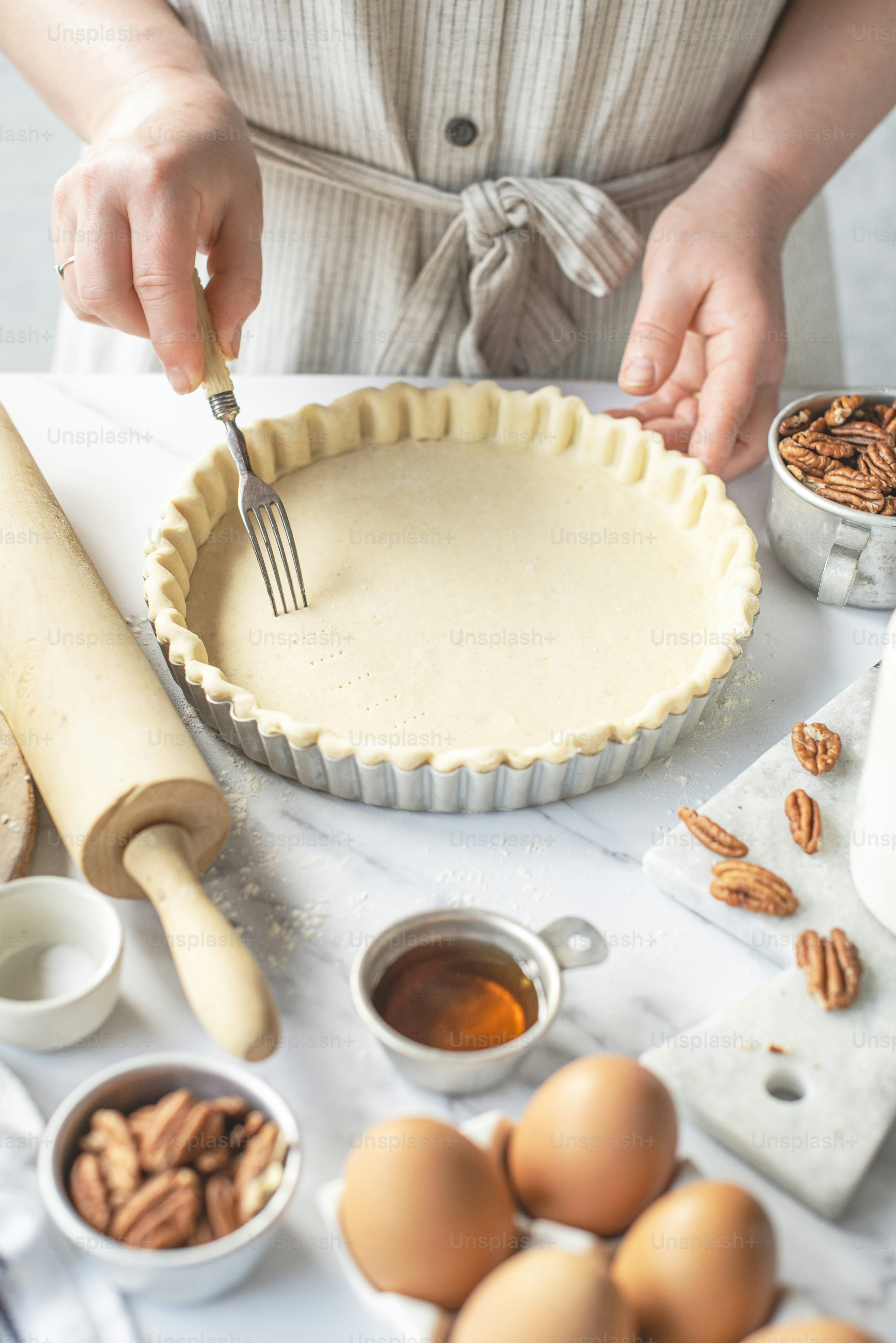 A person cutting a pie crust with a knife and fork photo – Baking pie ...