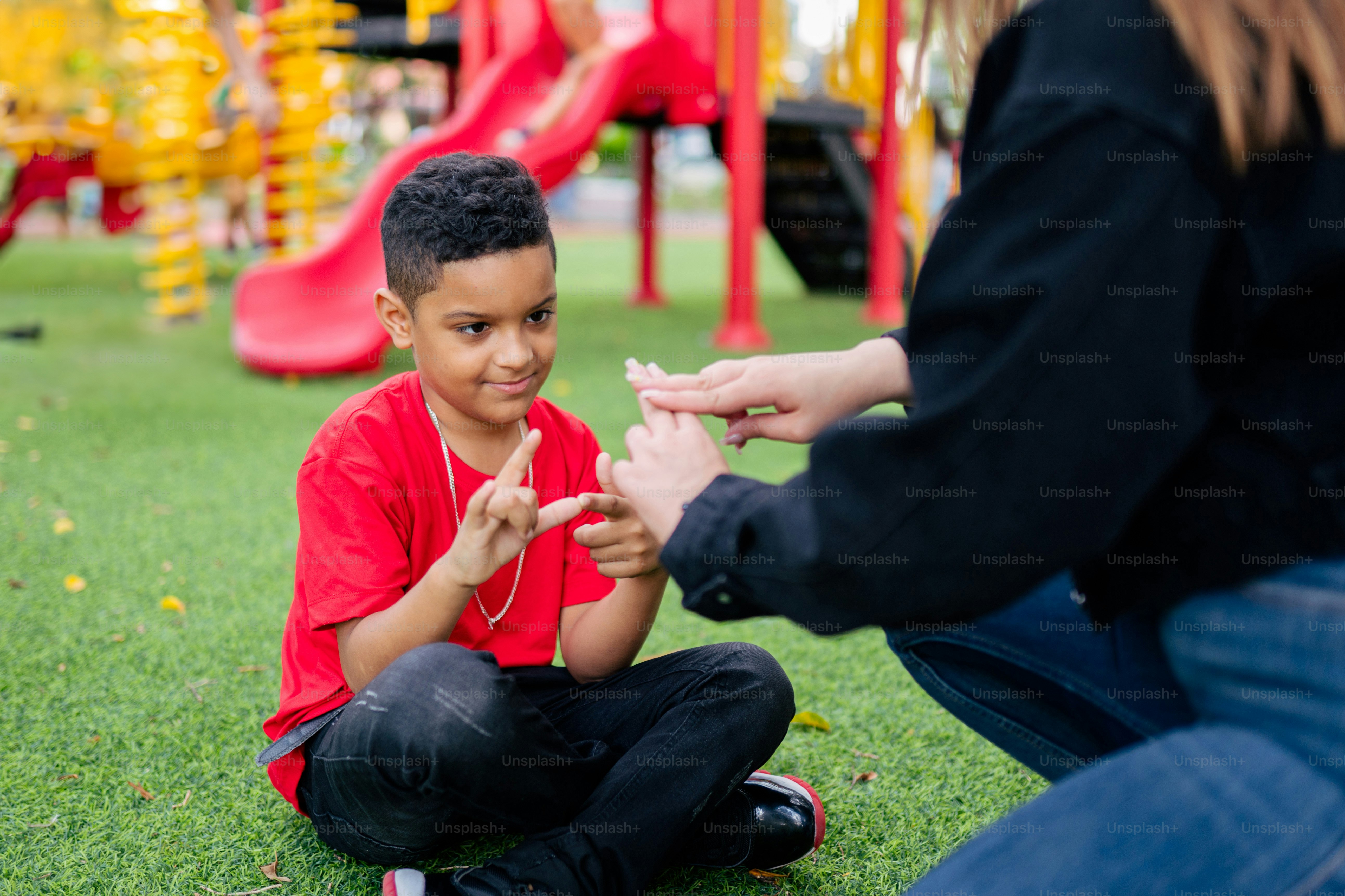 A little boy sitting on the ground with a woman photo – Autism Image on ...
