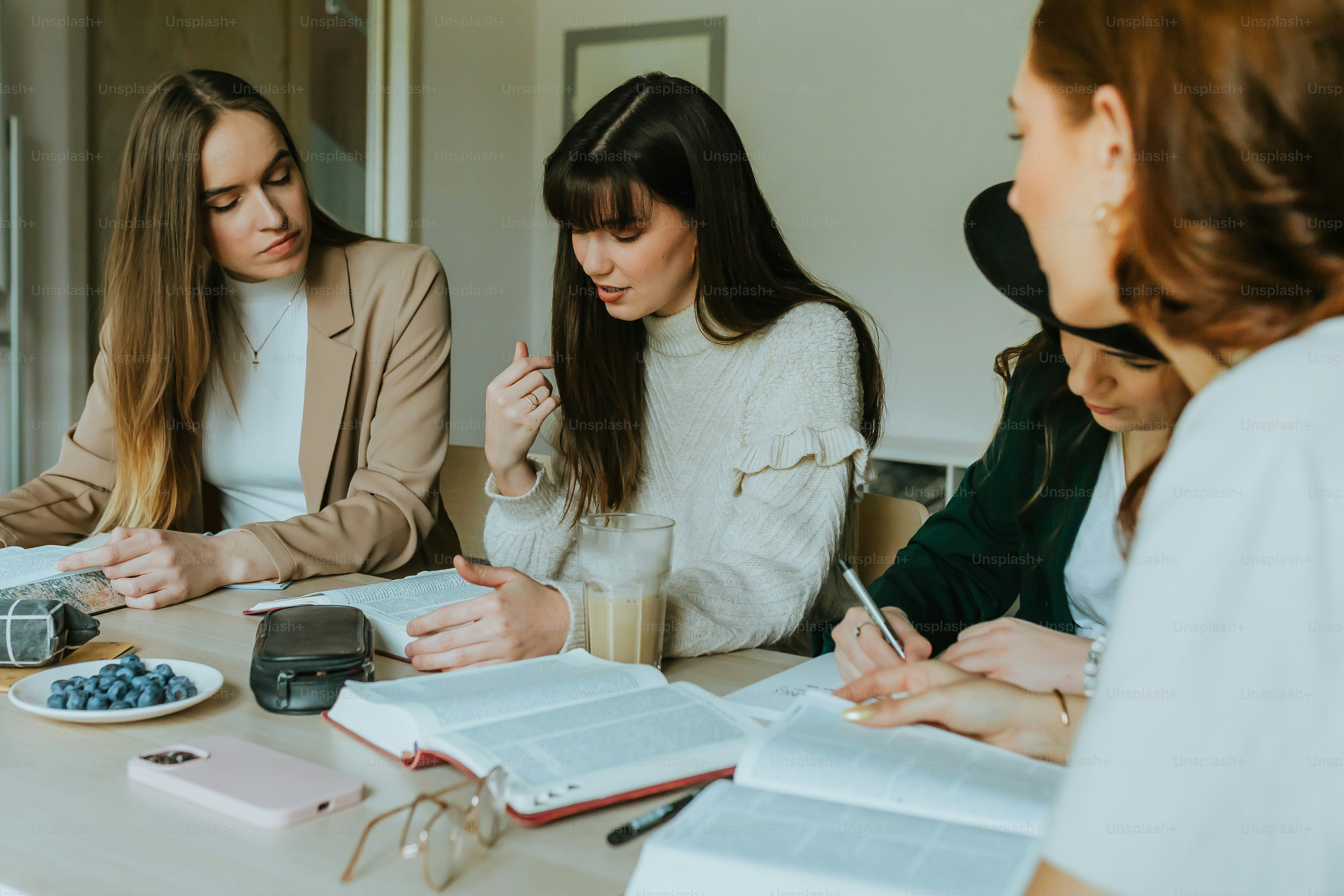 A group of women sitting around a table with books photo – Spiritual ...