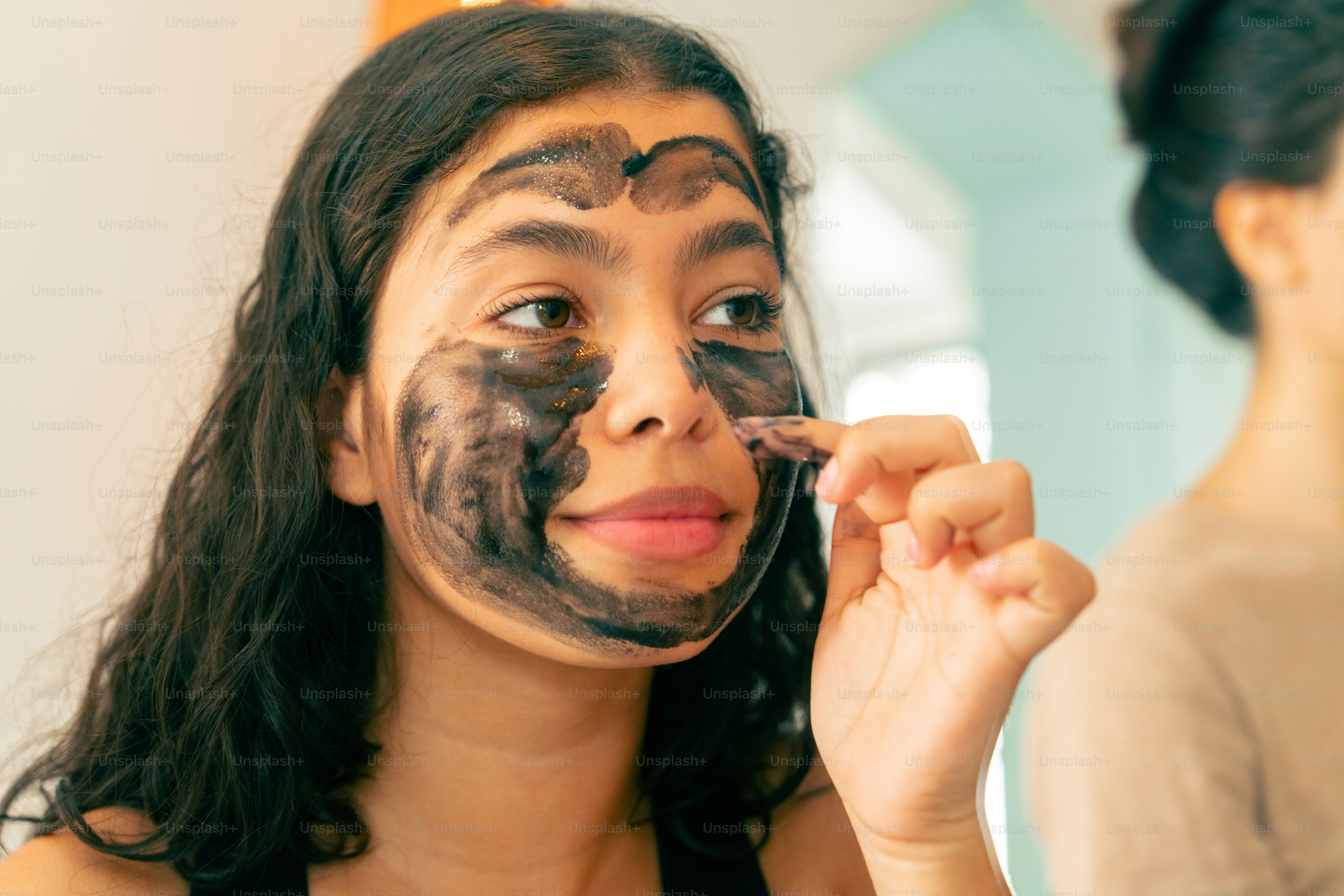 A woman is putting chocolate on her face photo – Self-care Image on ...