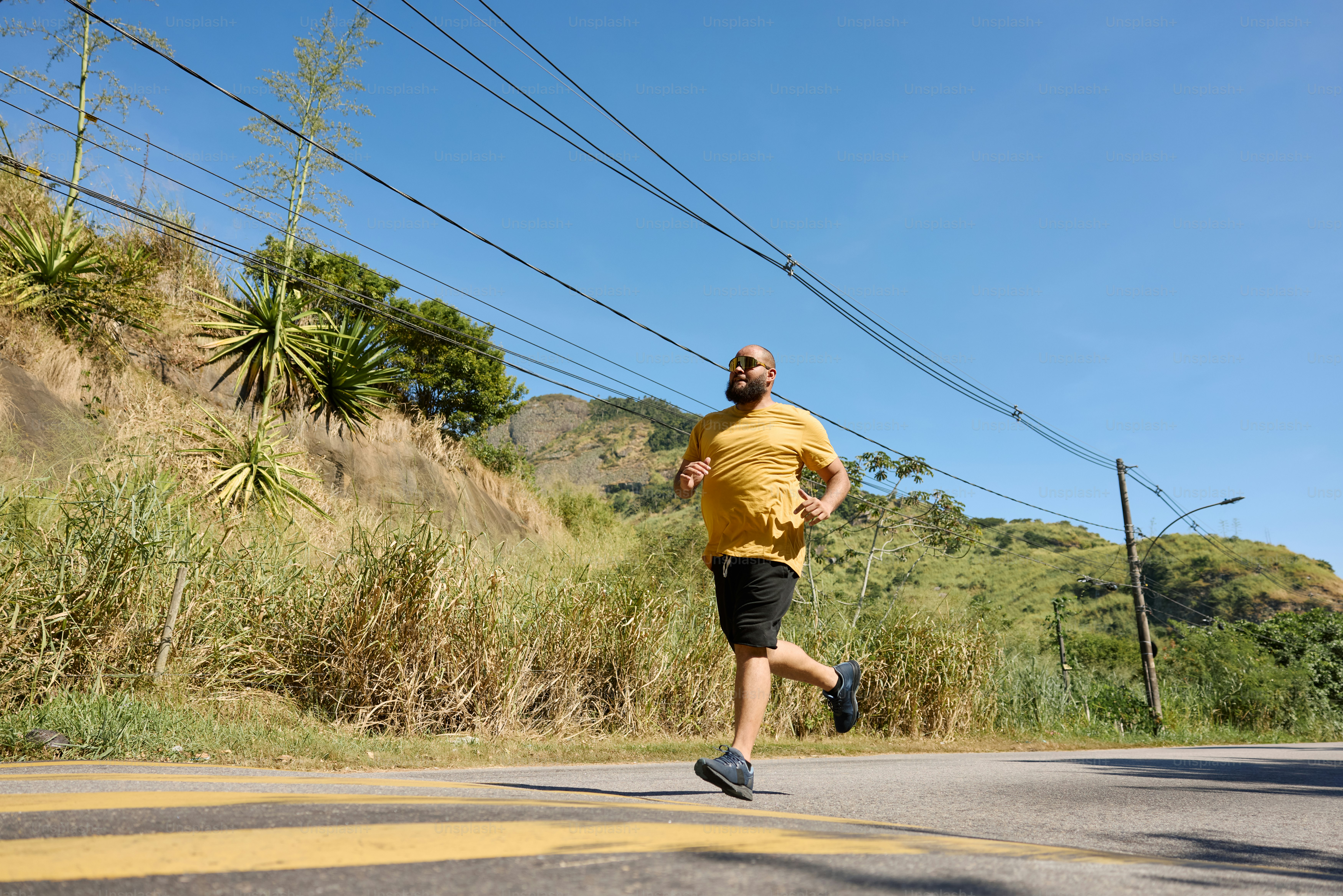 A man running down a street with power lines above him photo ...