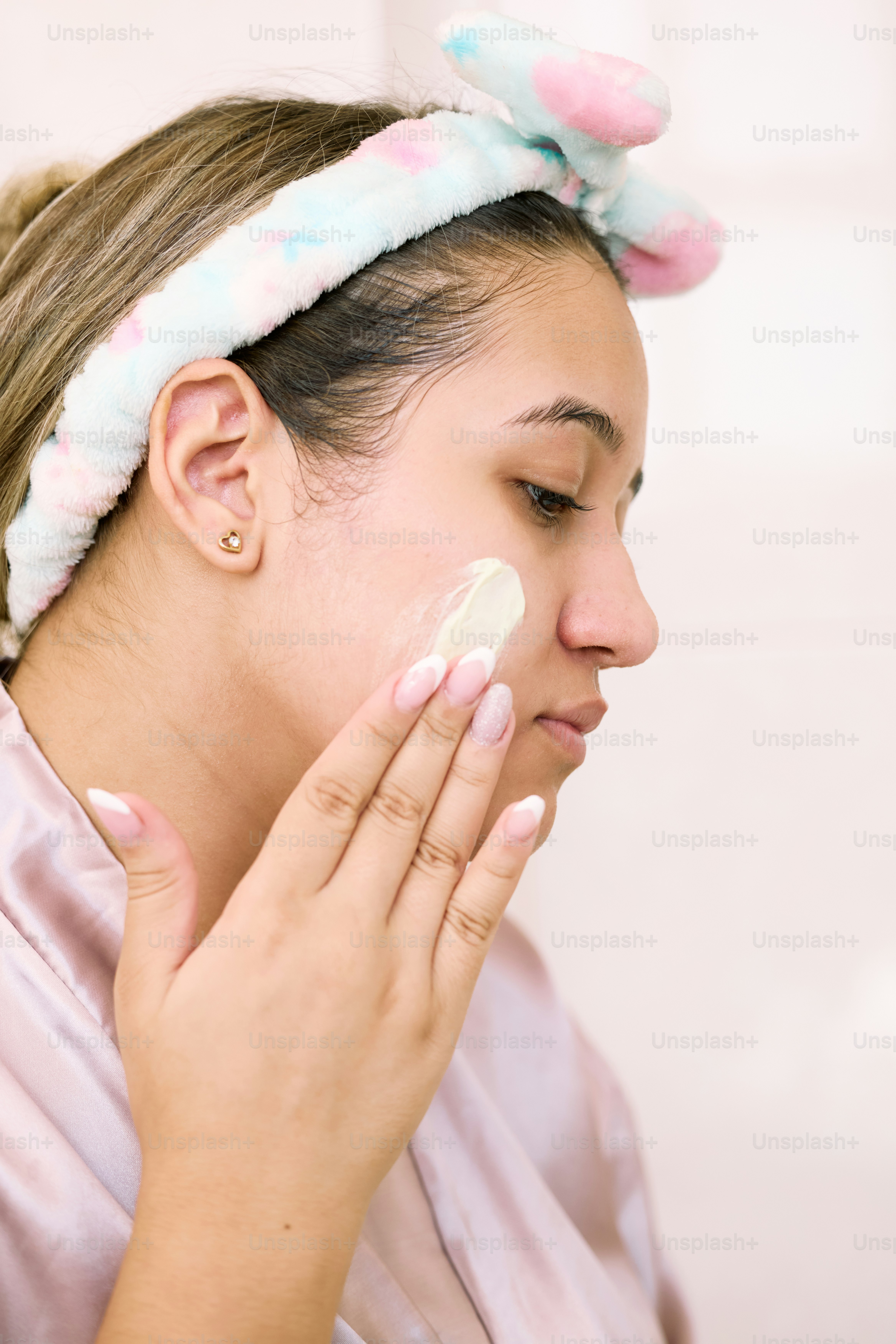 A woman is putting a lotion on her face photo – Health Image on Unsplash